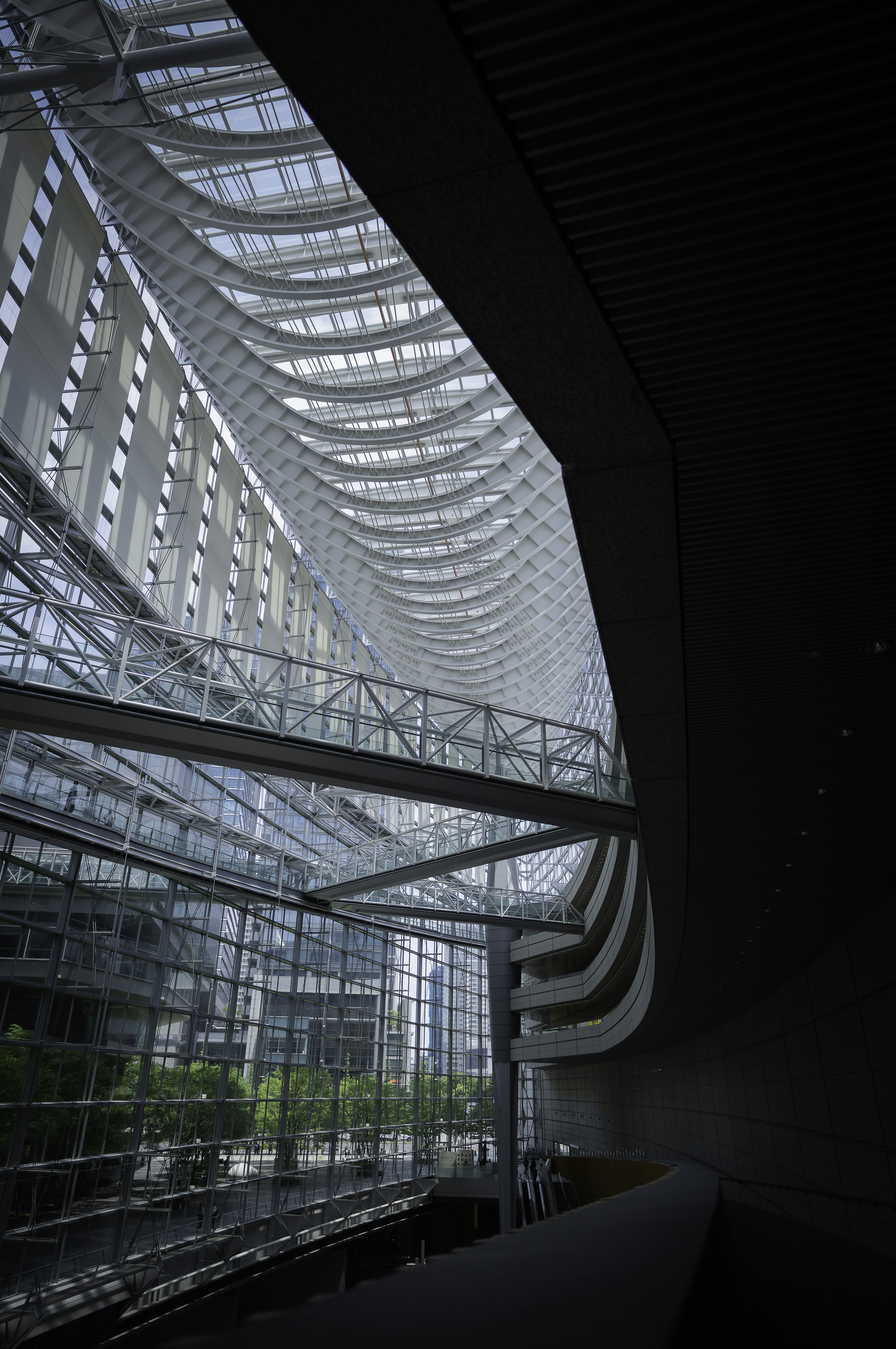 Modern building interior with curved glass ceiling and walkways.