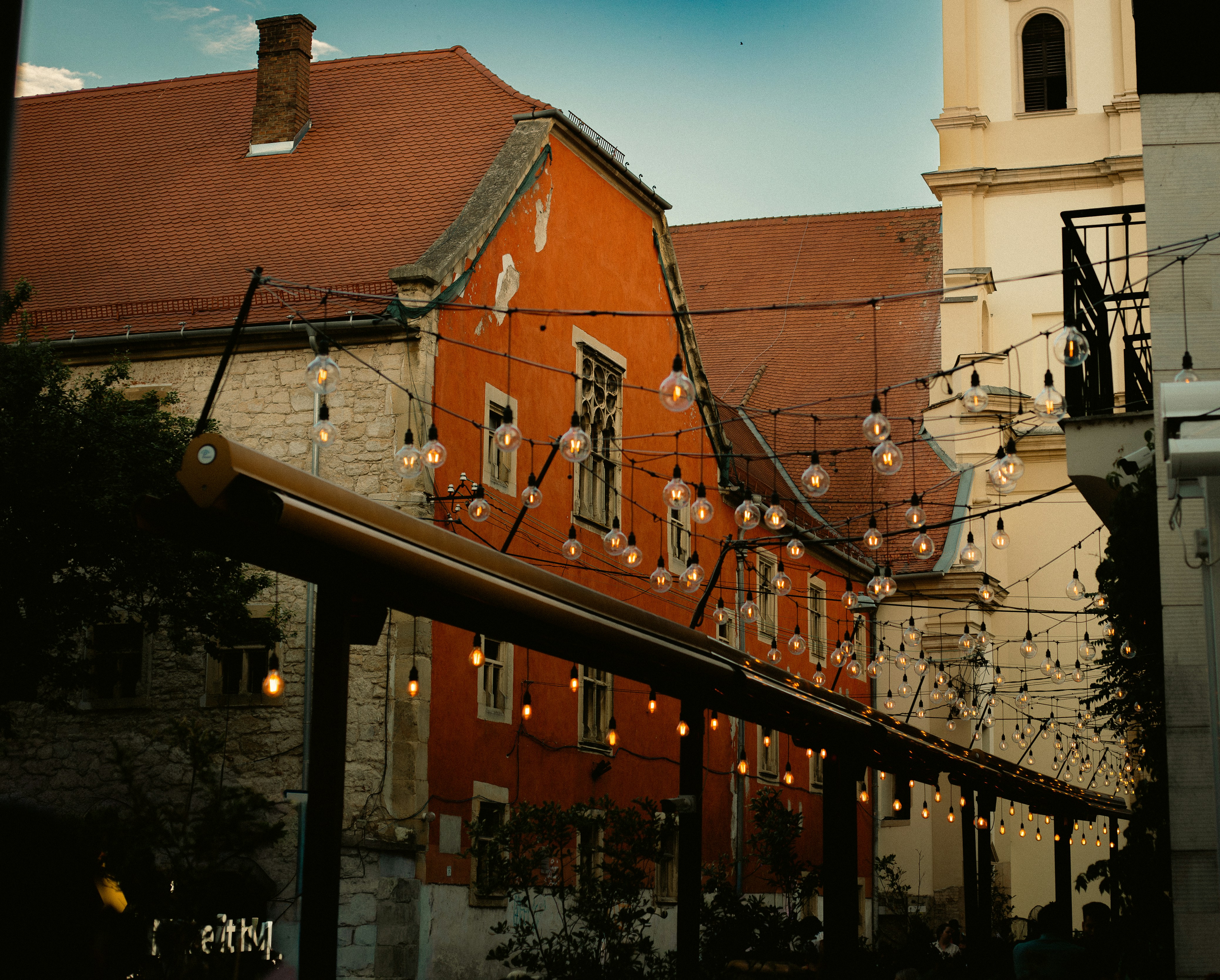 String Lights over Quiet Courtyard: An Evening in Orange Facades
