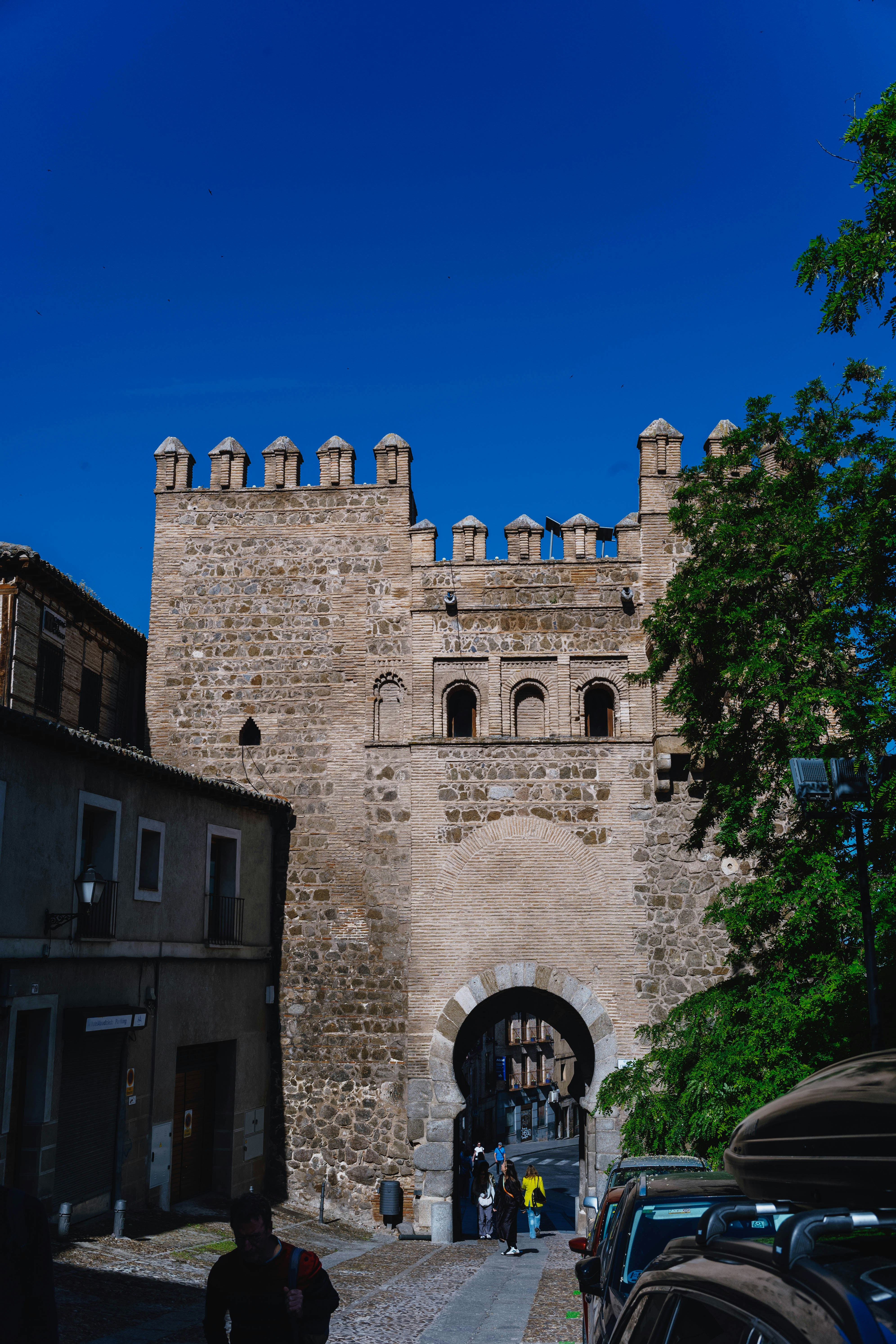 Ancient stone city gate under a clear blue sky.