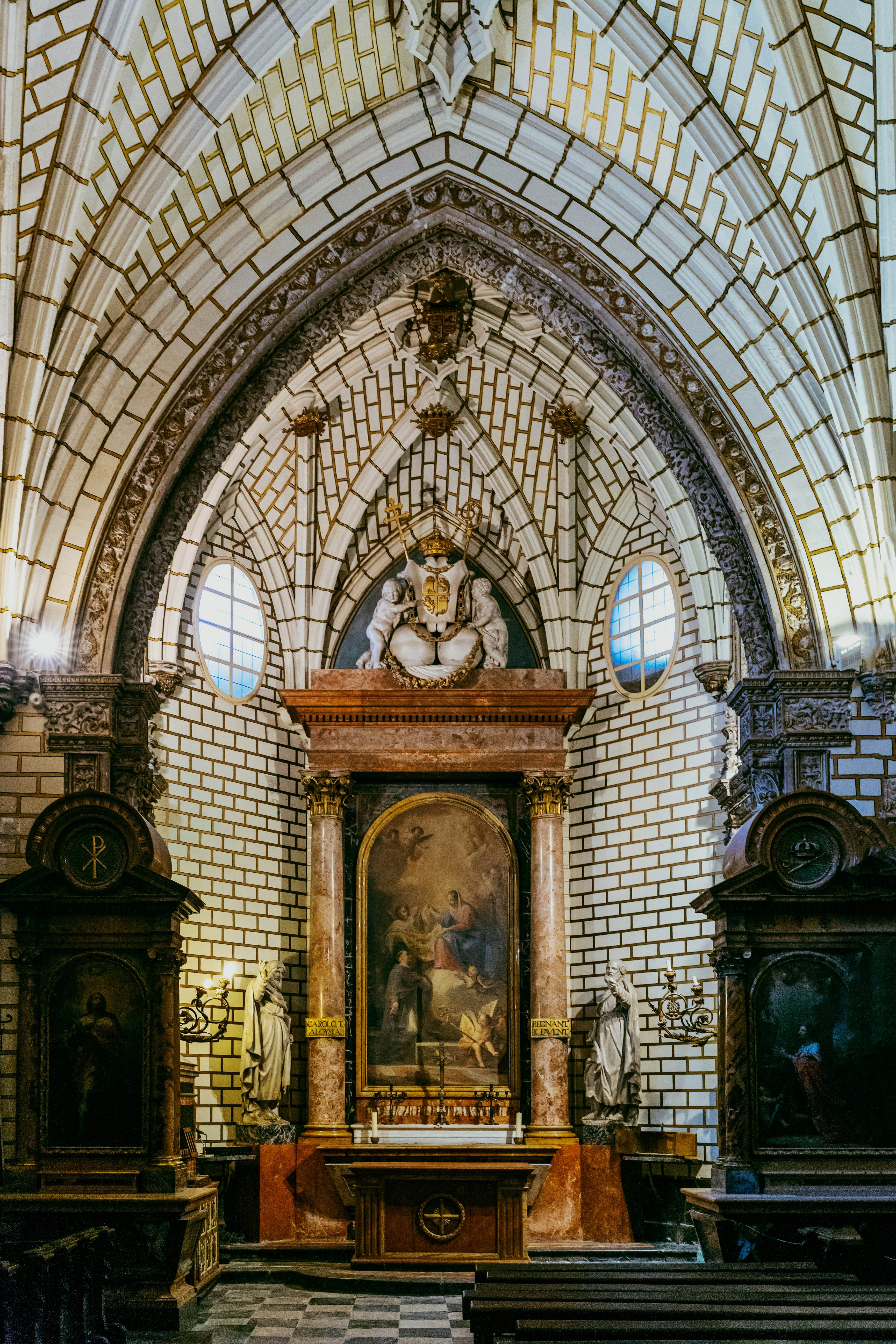 Ornate church interior with vaulted ceiling and central altar painting.