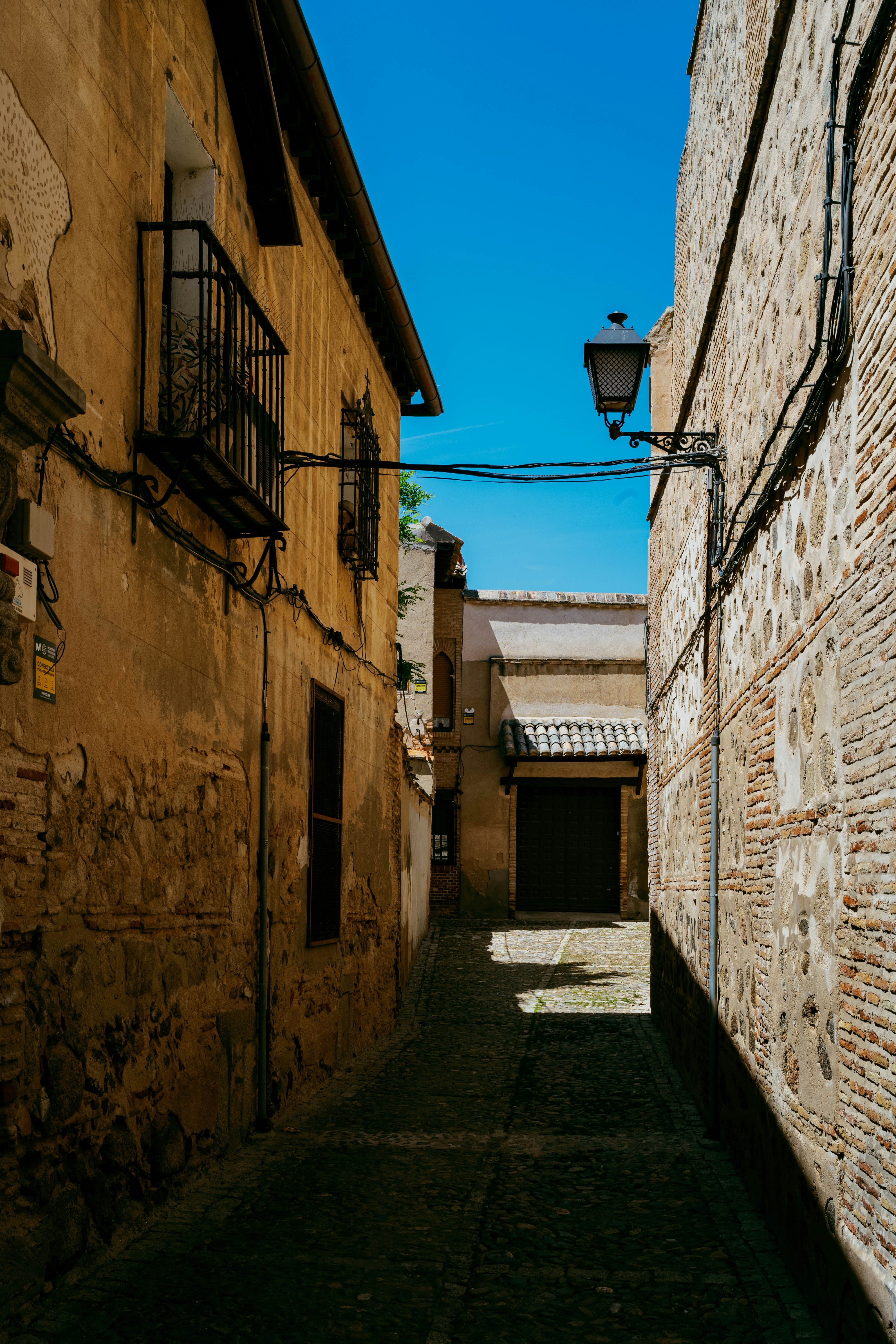 Sunlit Alleyway: A Narrow Medieval Street Between Timeless Walls