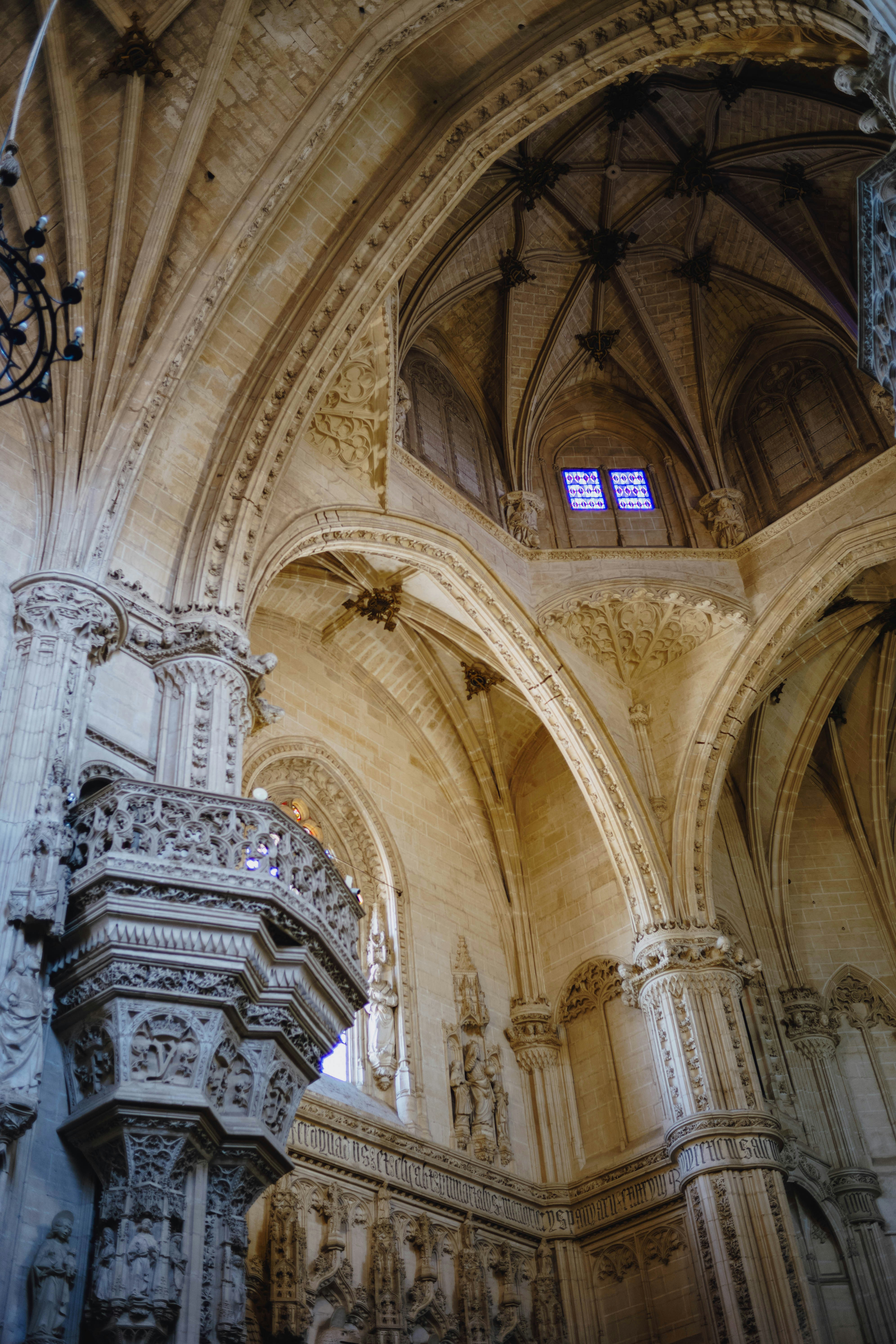 Ornate stone architecture with ribbed vaults and a decorative pulpit.