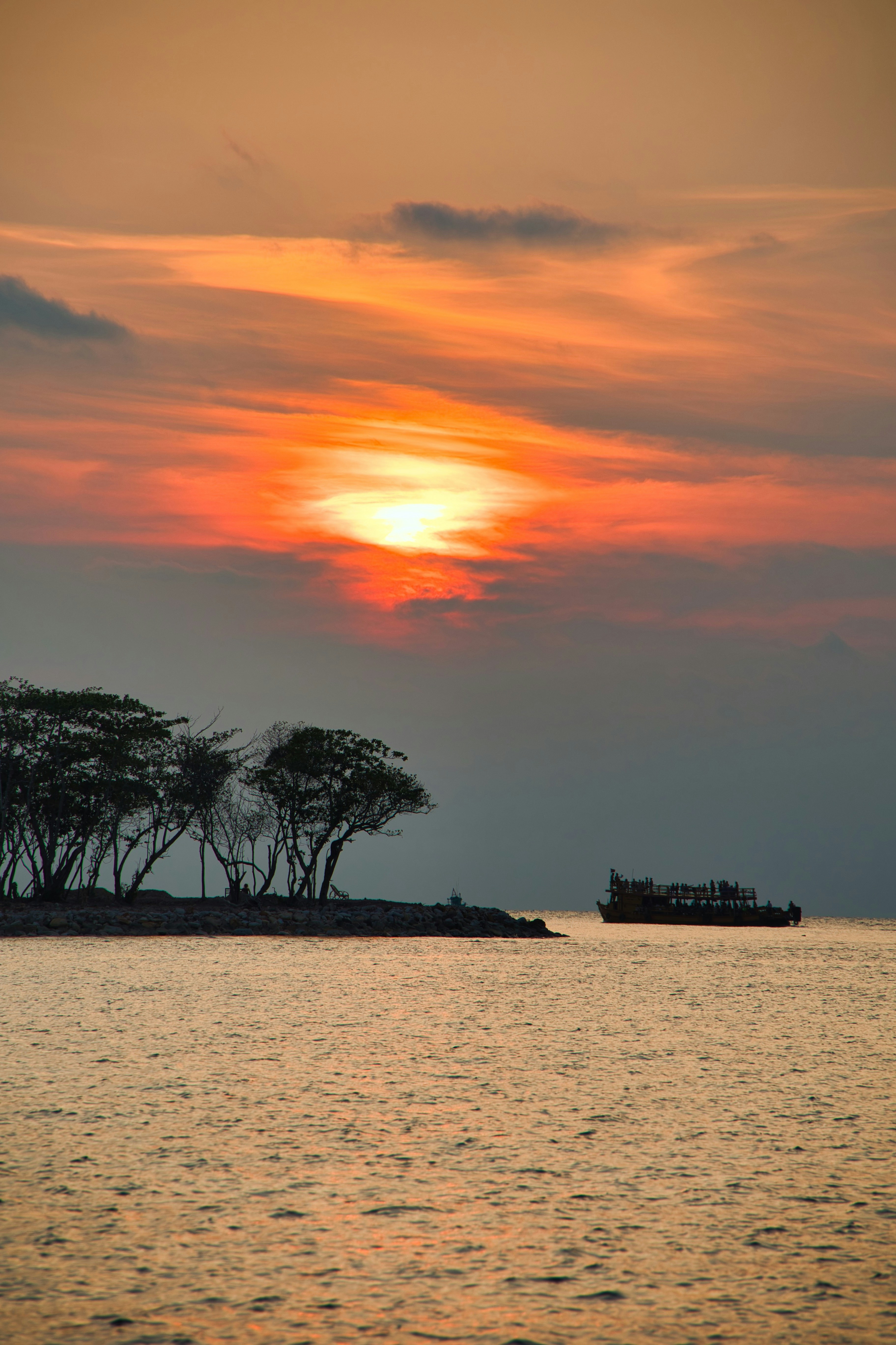 Sunset Silhouette: A Calm Pier of Trees and a Boat at Dusk