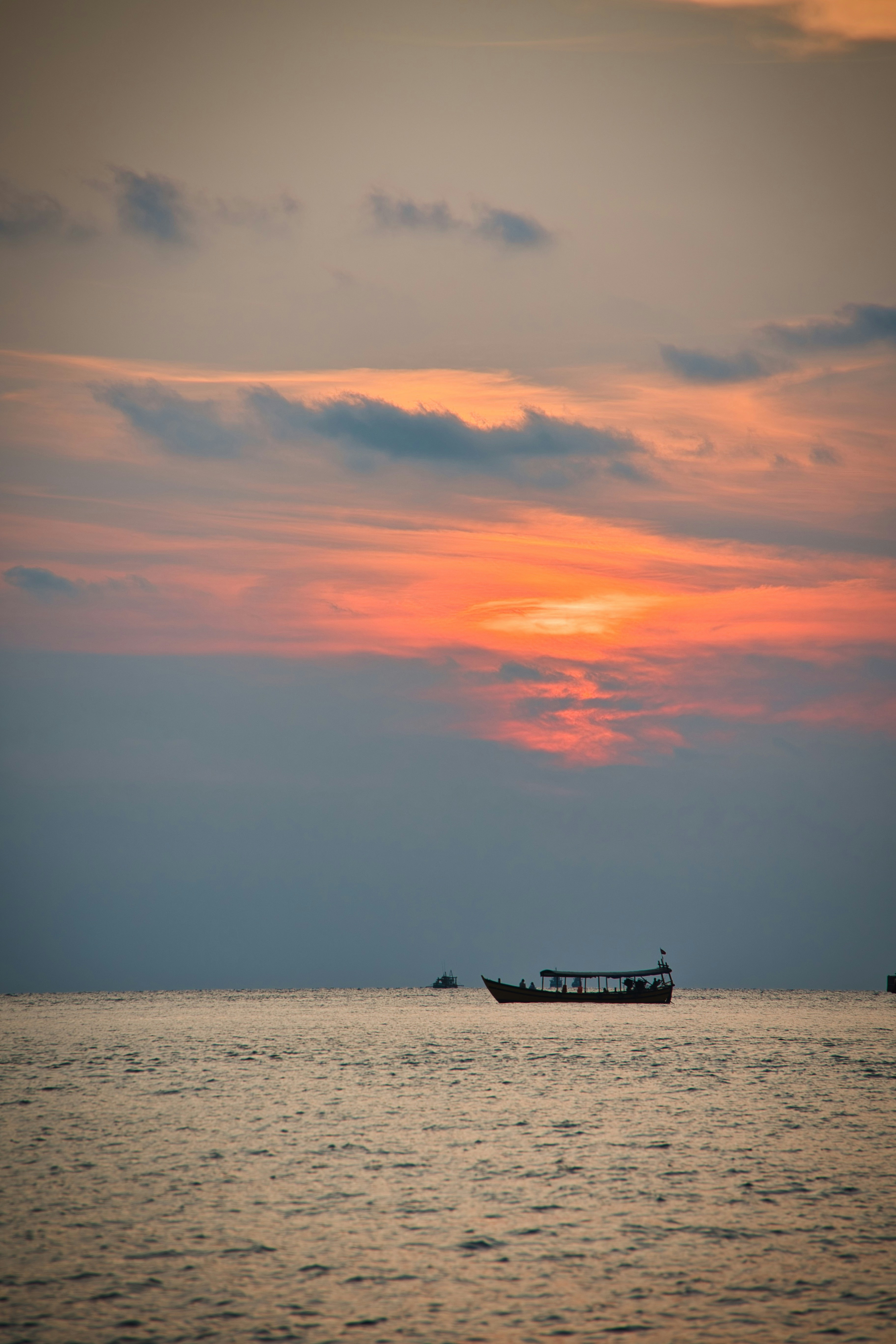 Sunset over a Quiet Bay: A Lone Boat on calm waters