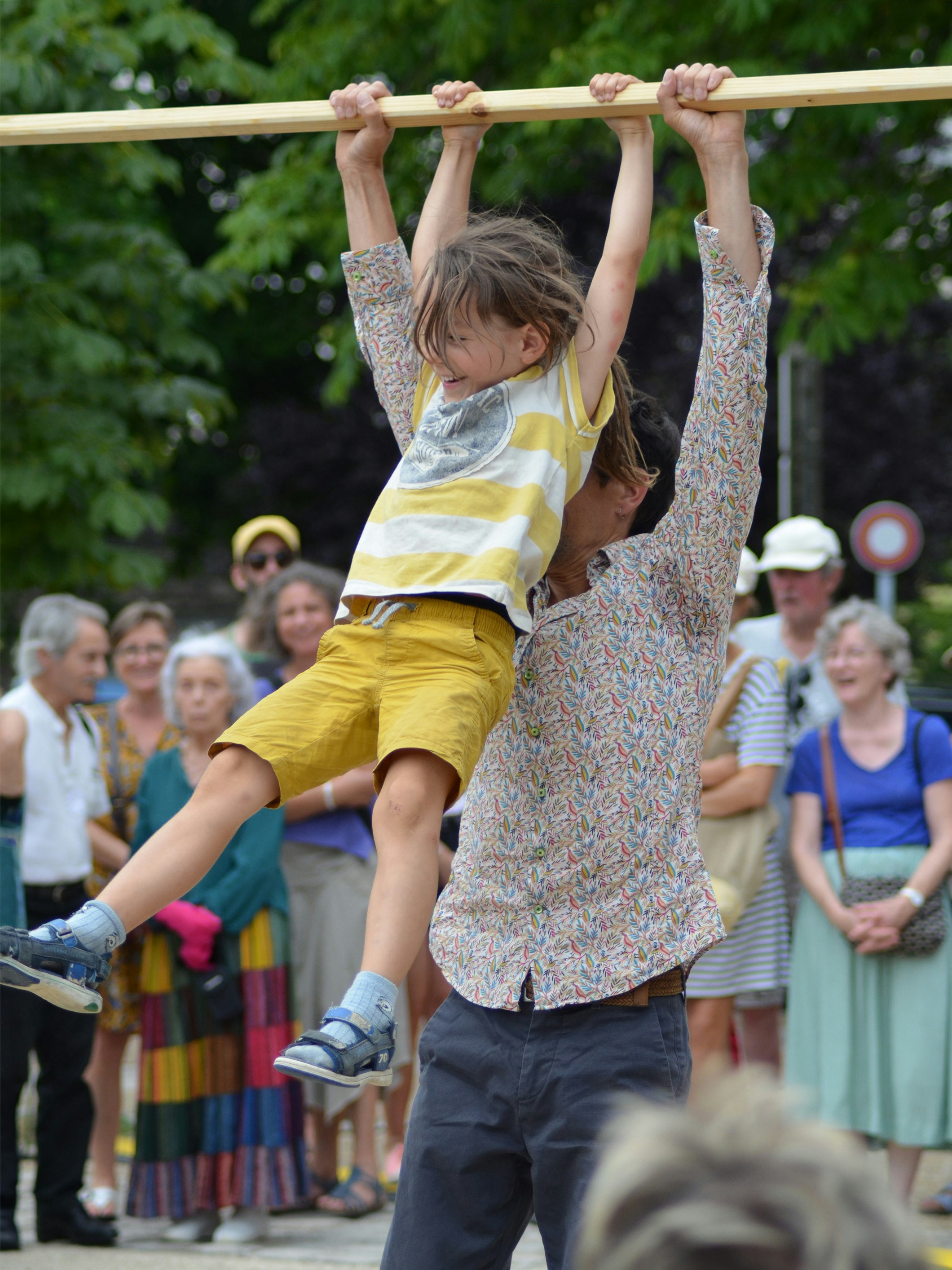 Young Acrobatic Moment: A Child Lift Under a Wooden Bar