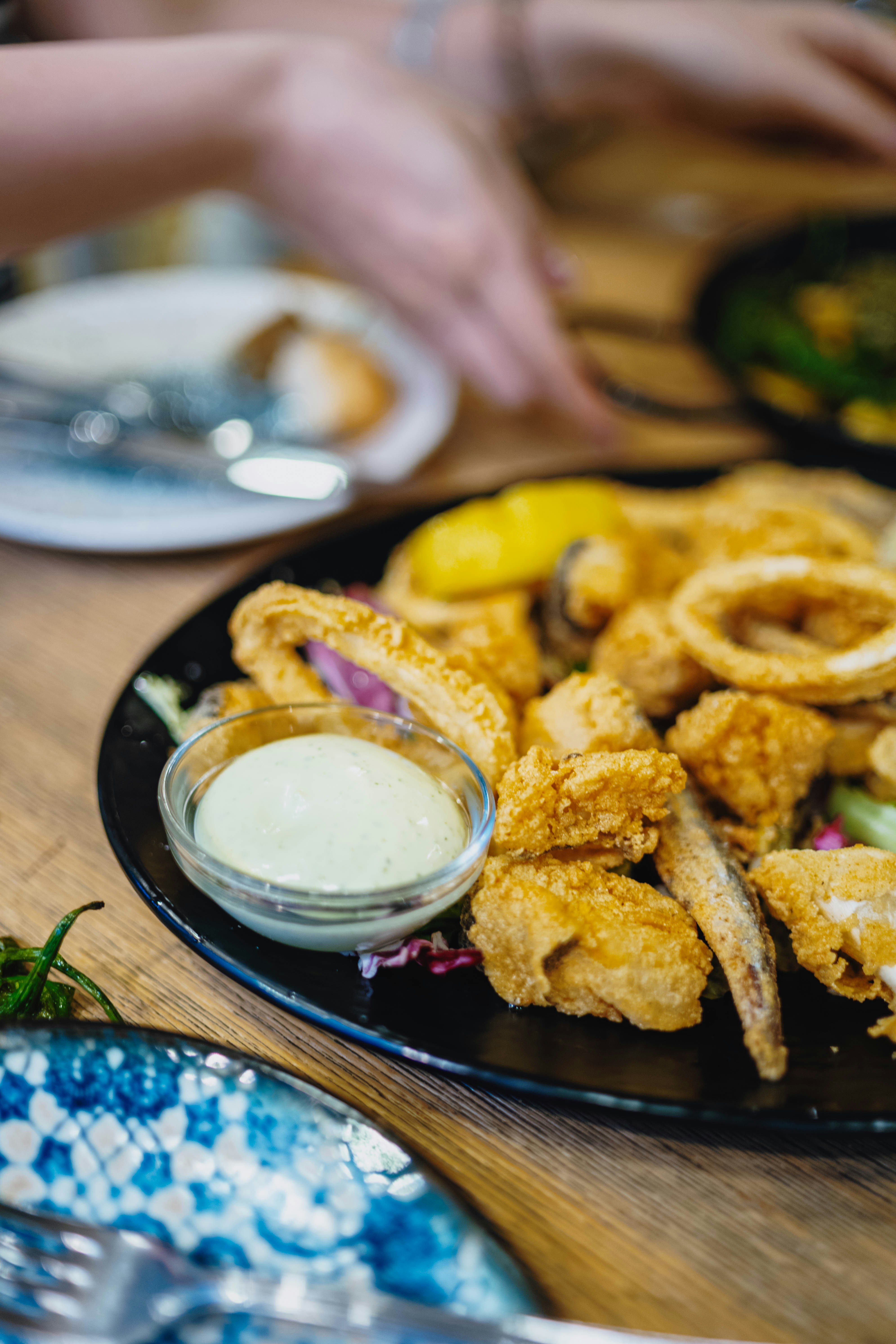 Crispy Seafood Platter with Dipping Sauce on a Dark Plate