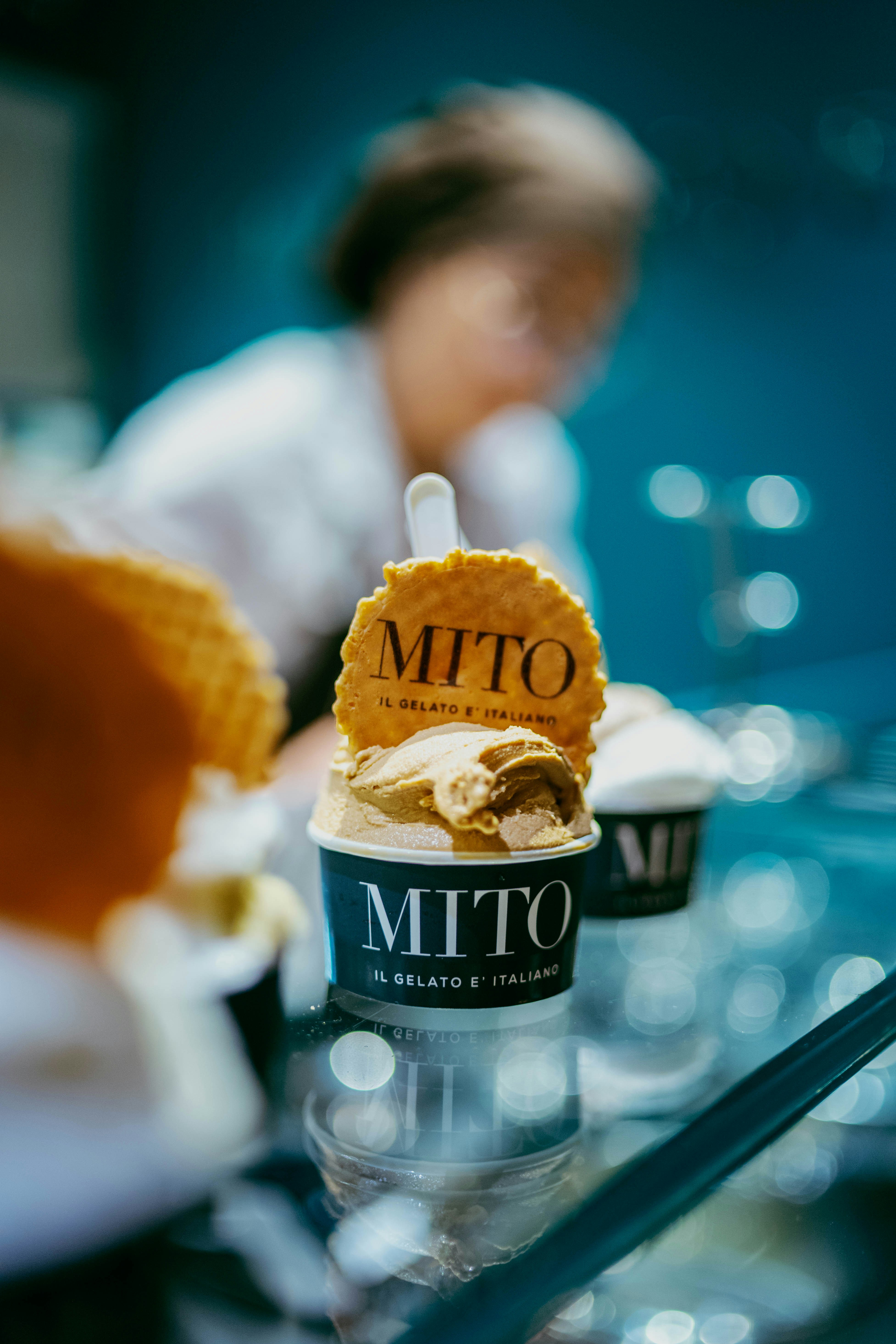 A cup of mito gelato with a branded wafer.