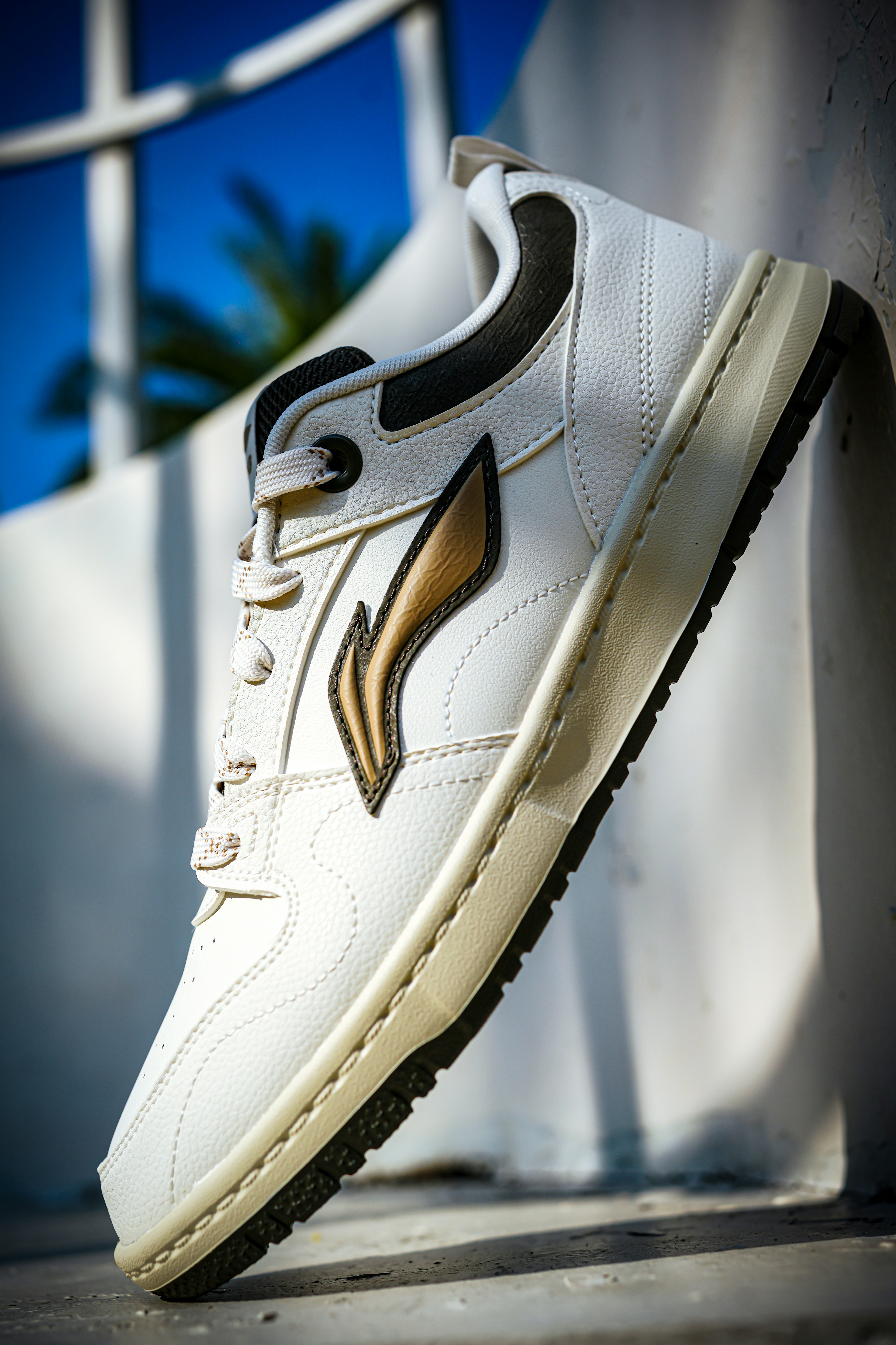 Step into Focus: White sneaker tilted against a sunlit urban backdrop