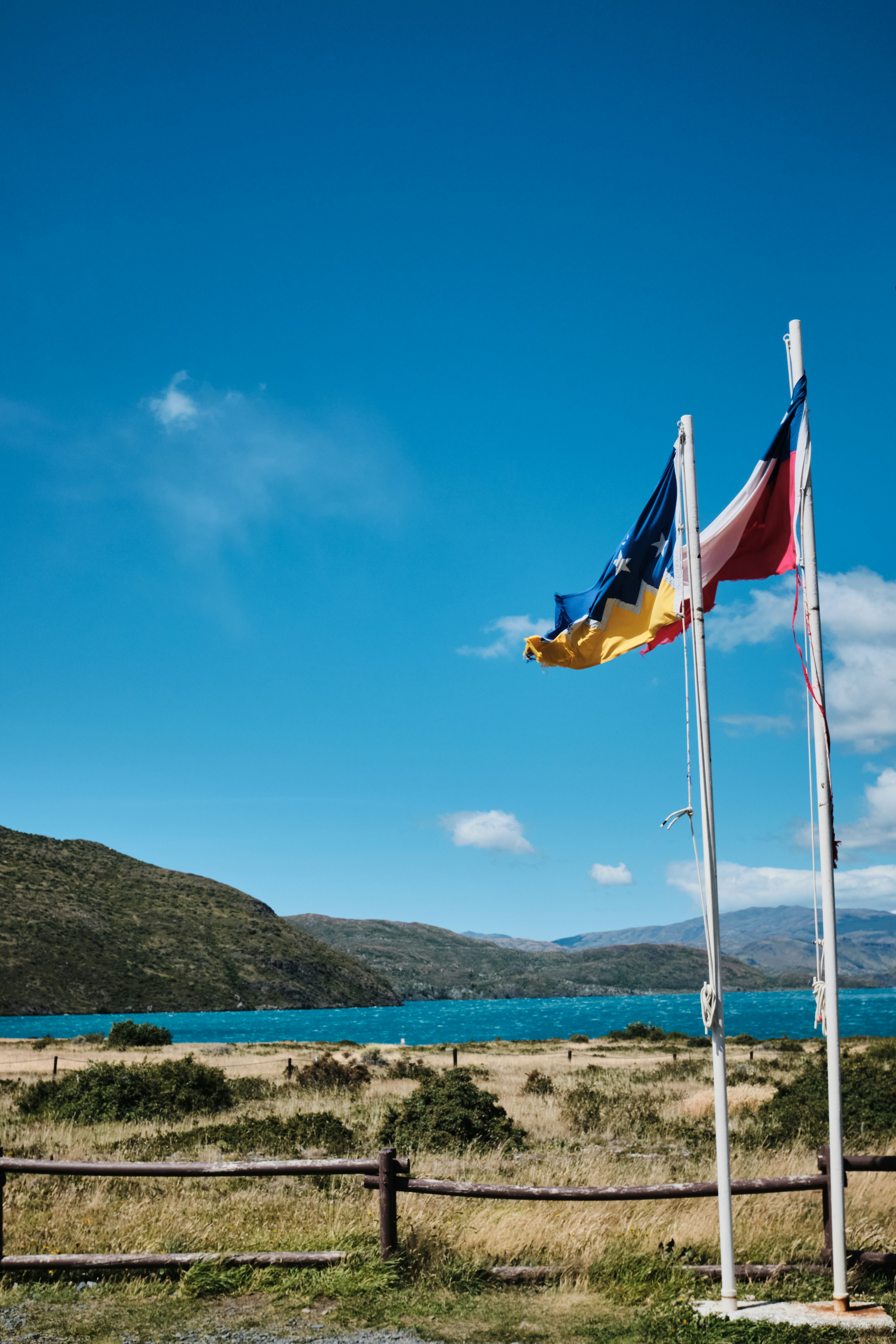 Flags at Blue Wind: A Shoreline Between Sky and Sea
