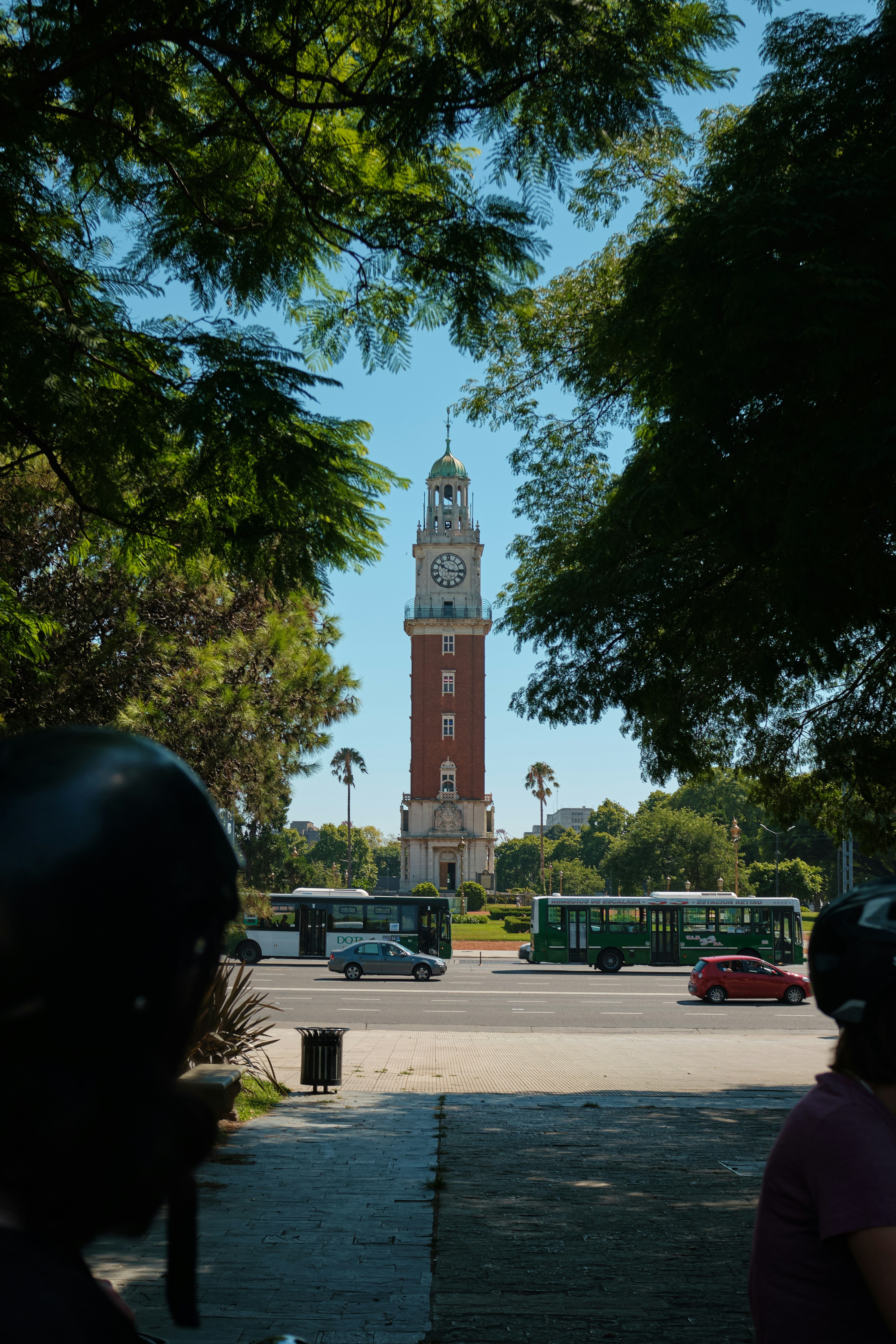 Clock Tower Framed by Green Canopy and Evening Street Scene