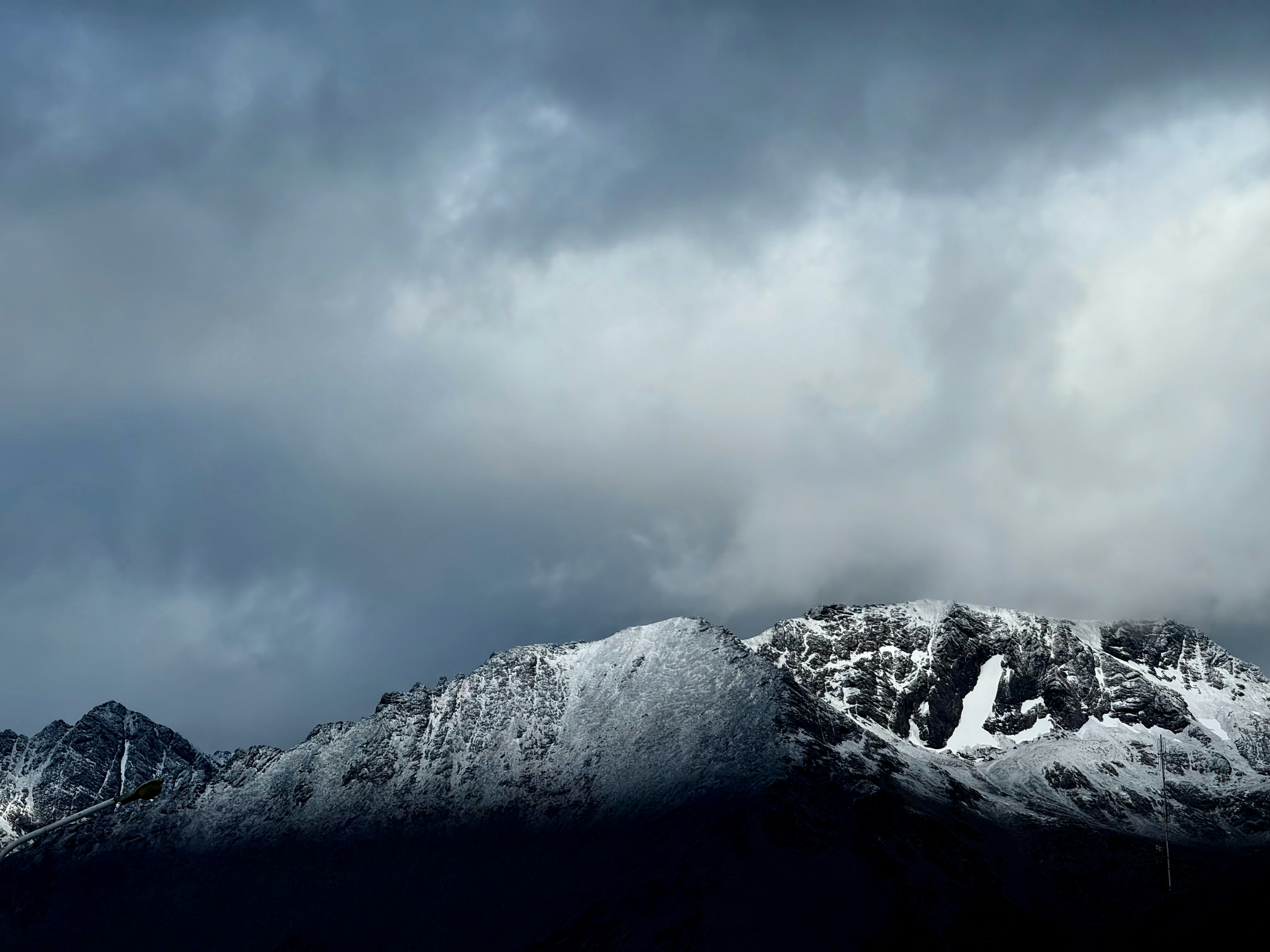 Snow-kissed Ridge Under a Brooding Sky
