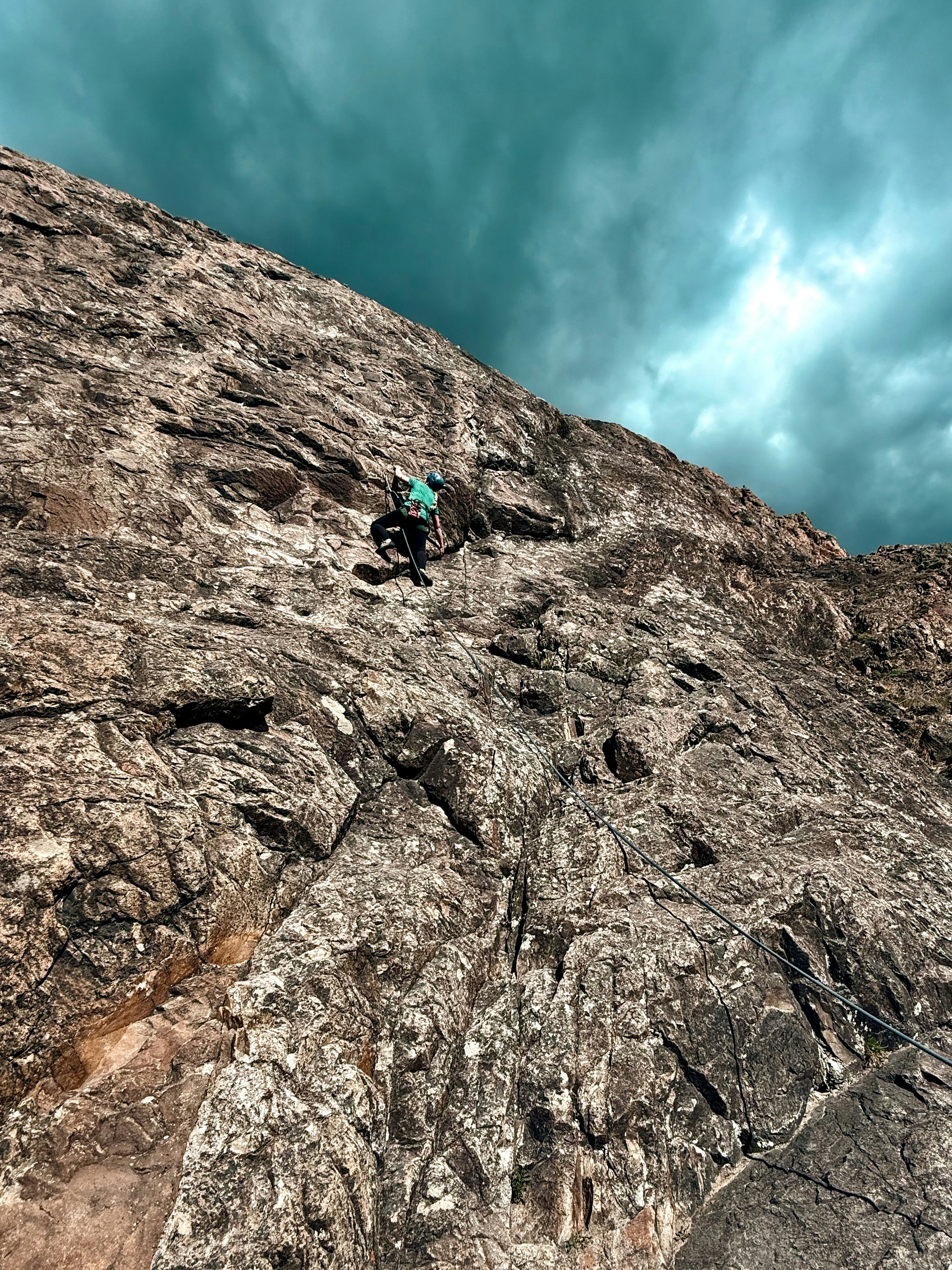 Climber Rises on a Jagged Cliff Beneath a Turquoise Sky