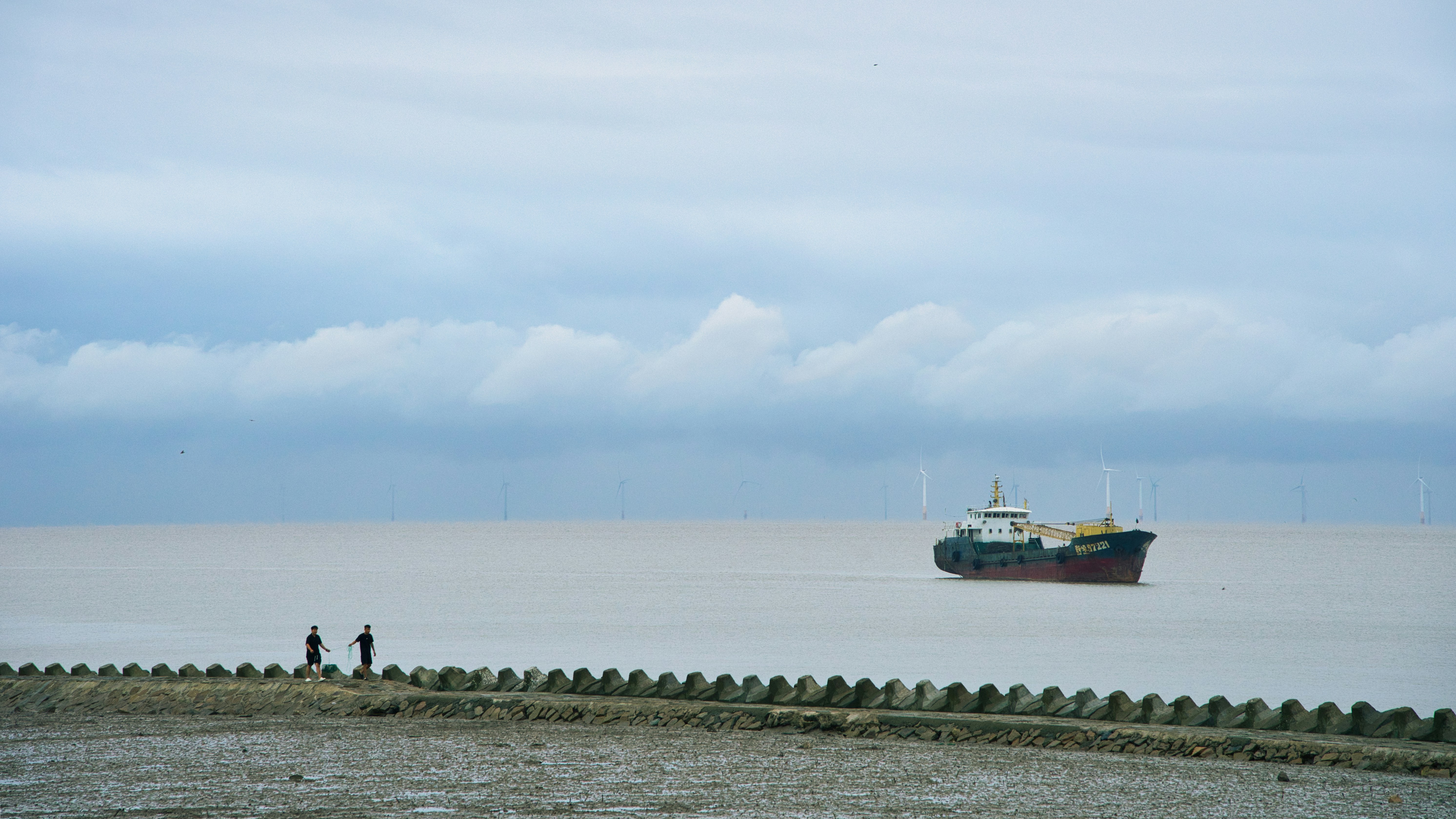 Harbor Bound: A Lone Cargo Vessel and Distant Crew