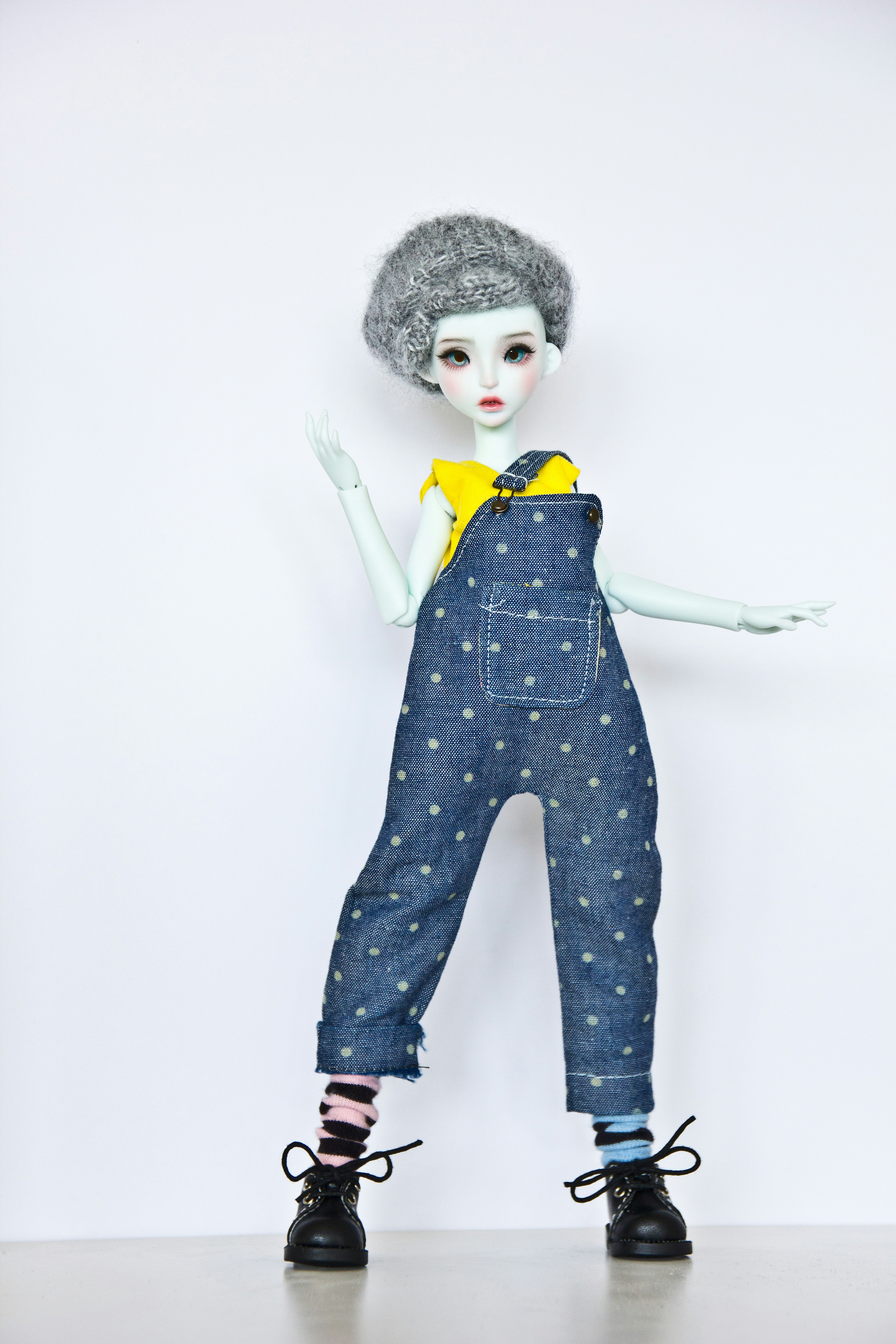 Polished Doll in Denim Overalls Strikes a Playful Pose