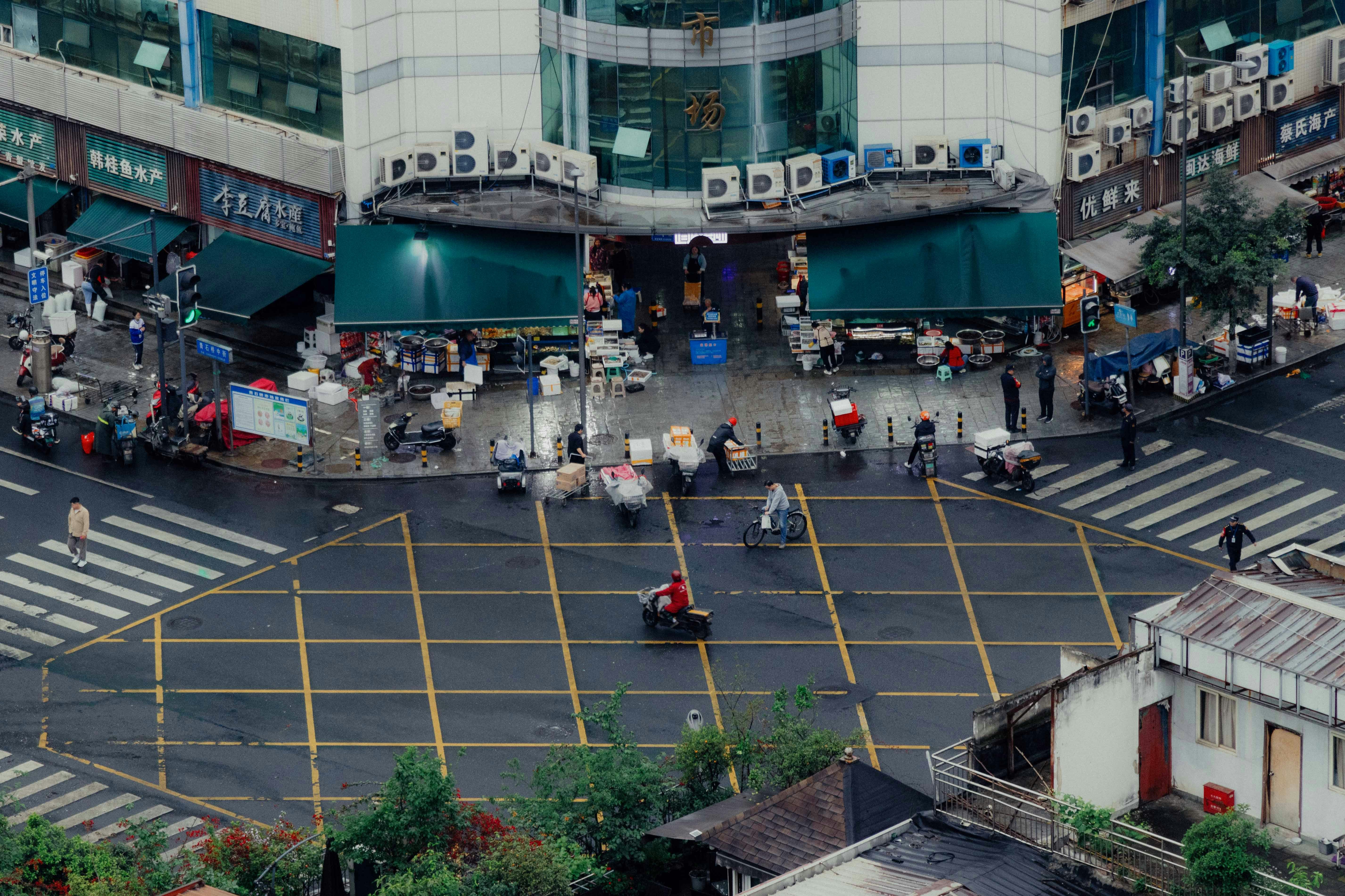 Aerial Pulse: Crossroads Market Women and Motorbikes in a Bustling City Block