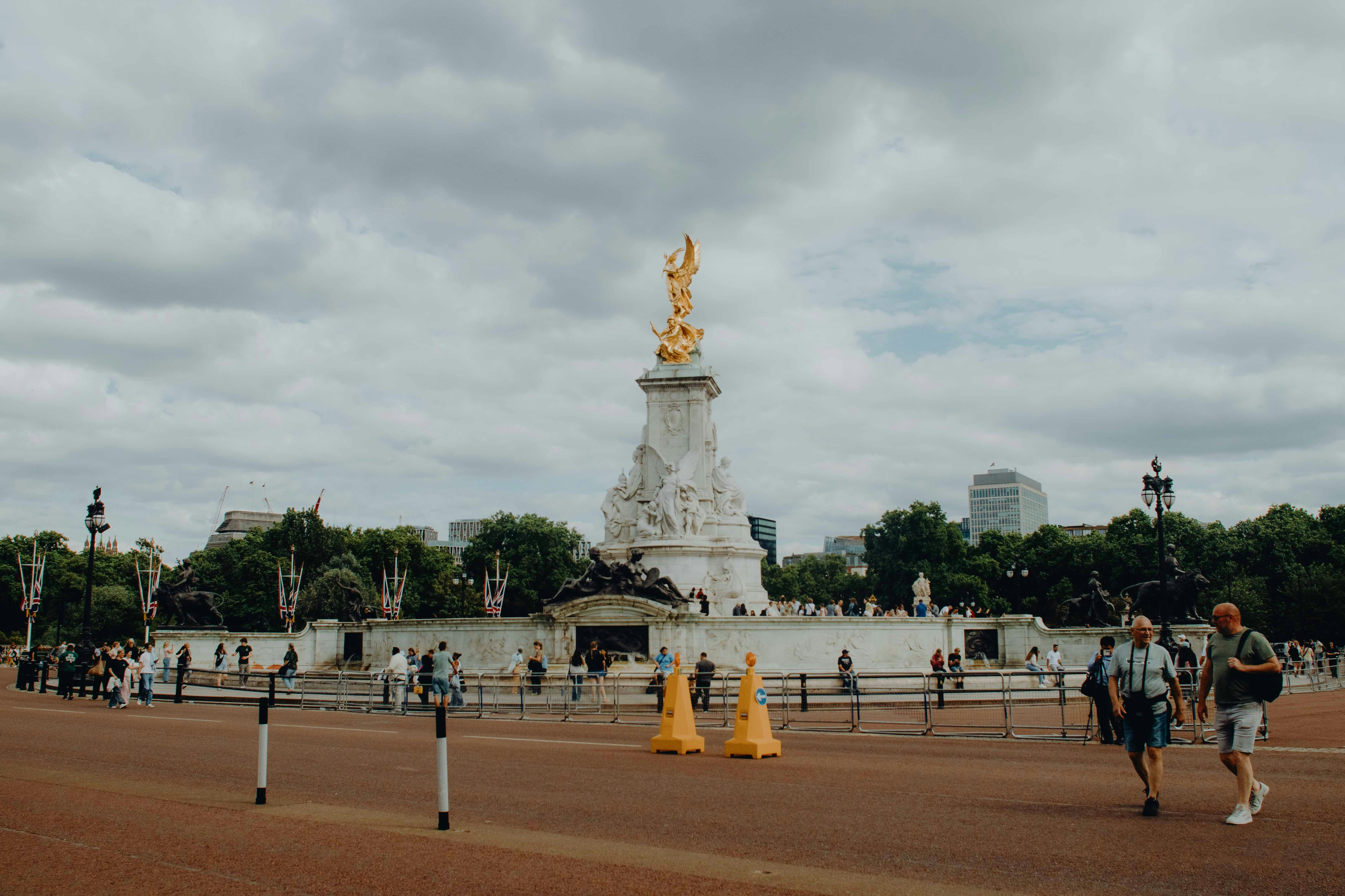 Monument in the Square: Golden Flame Rising Over a Bustling City Plaza