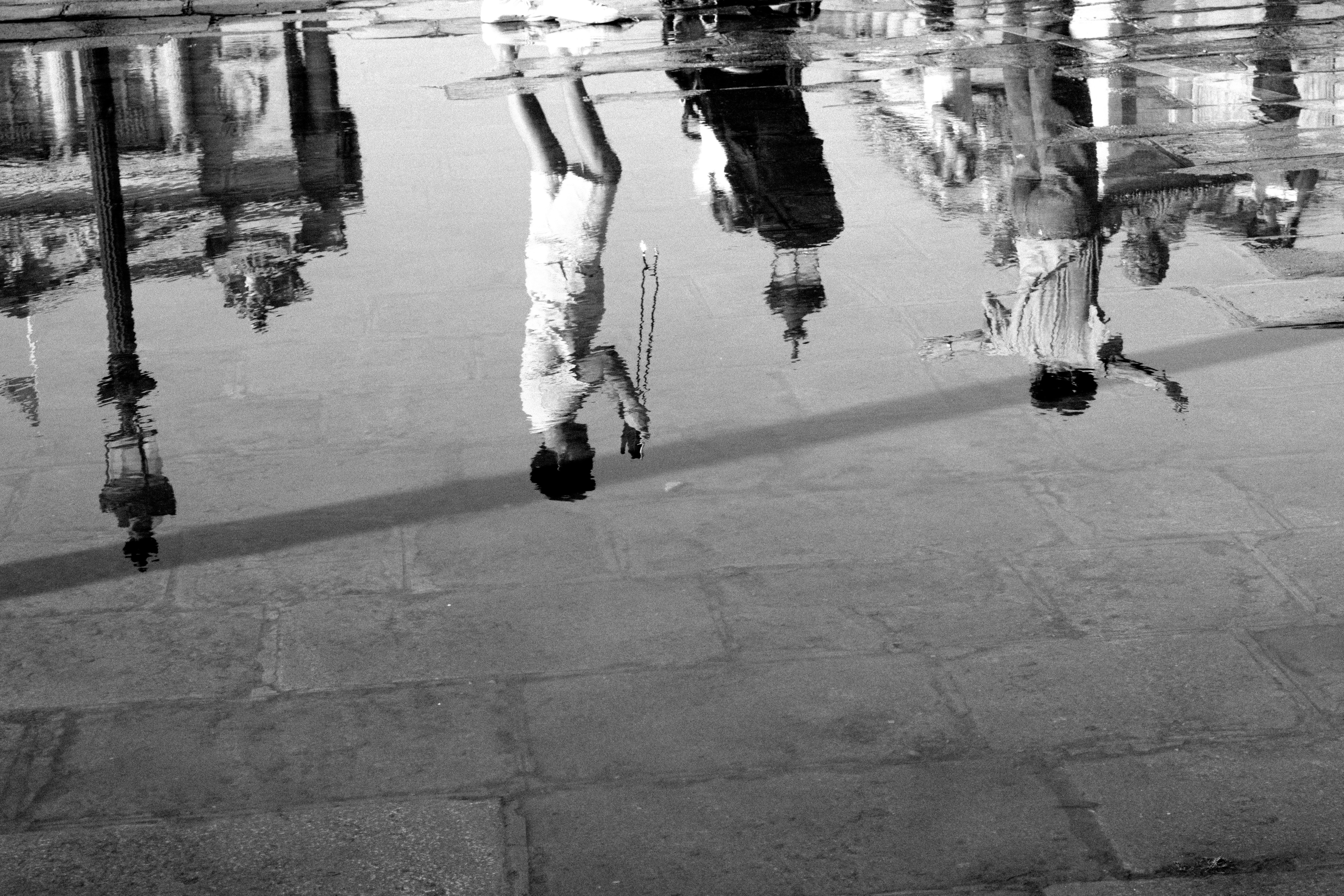 Reflected Footsteps: People and Polished Tiles in a Quiet Square