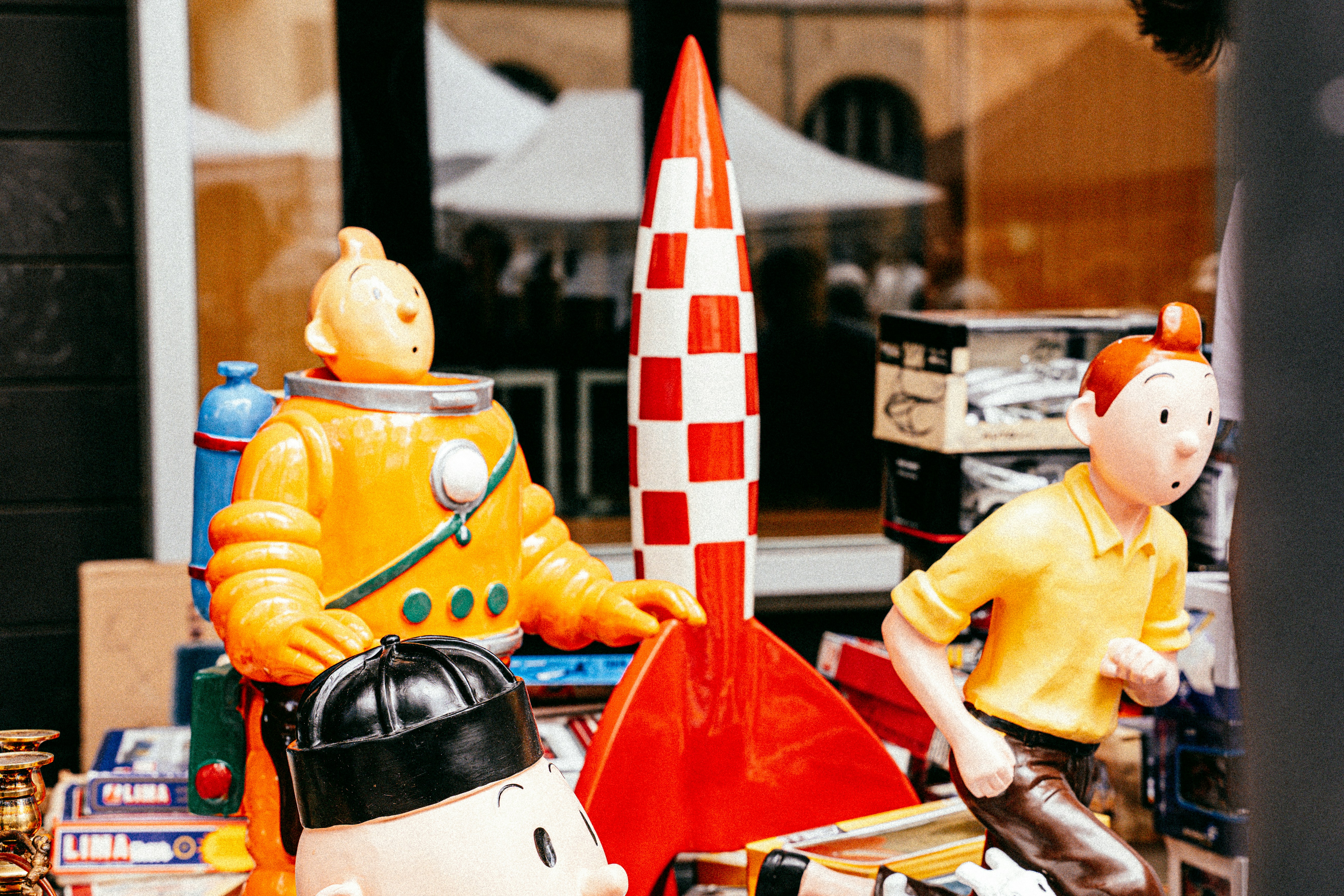 Tintin rocket and character figures displayed in a shop.