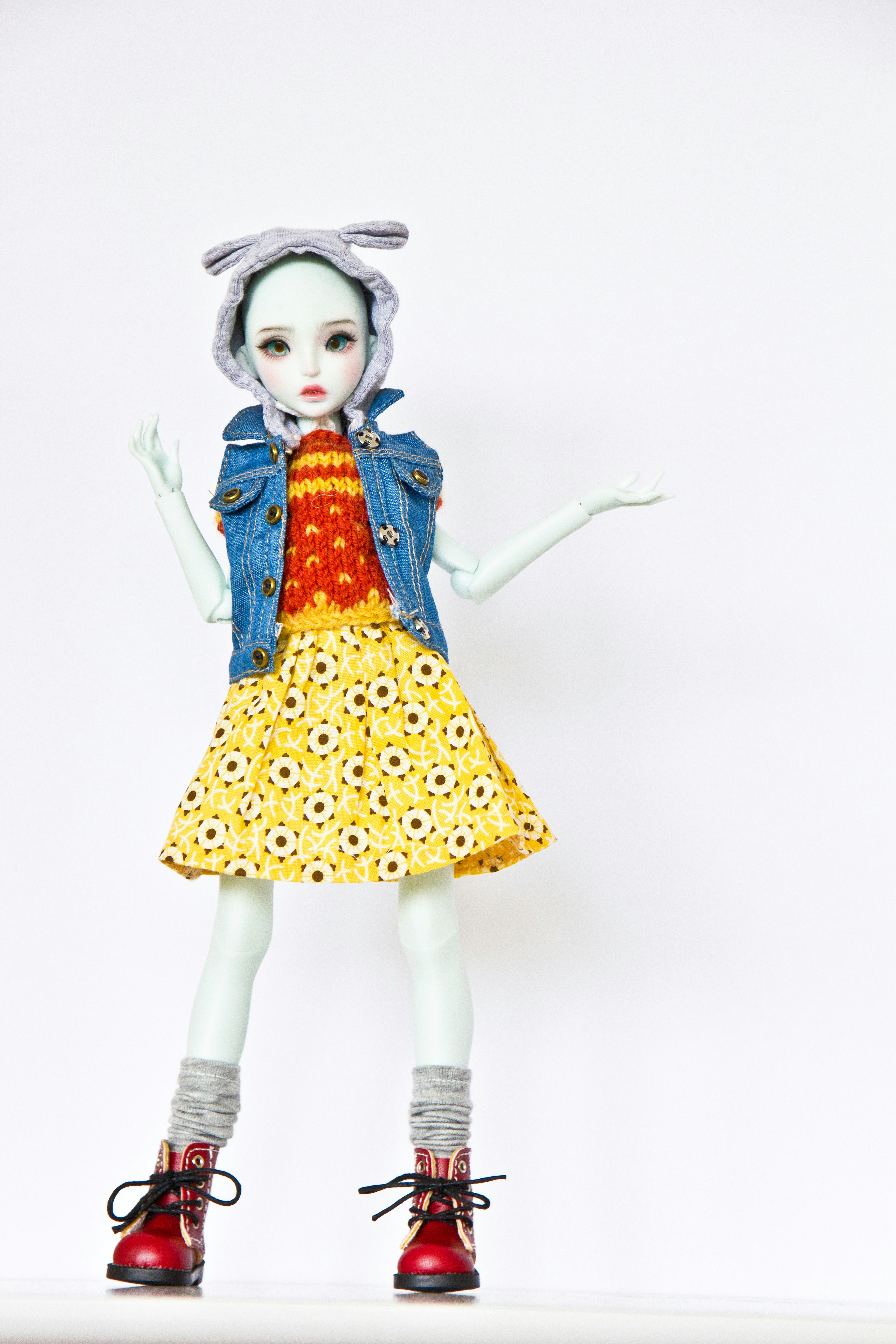 Youthful Doll in Denim Vest and Floral Skirt Strikes a Playful Pose