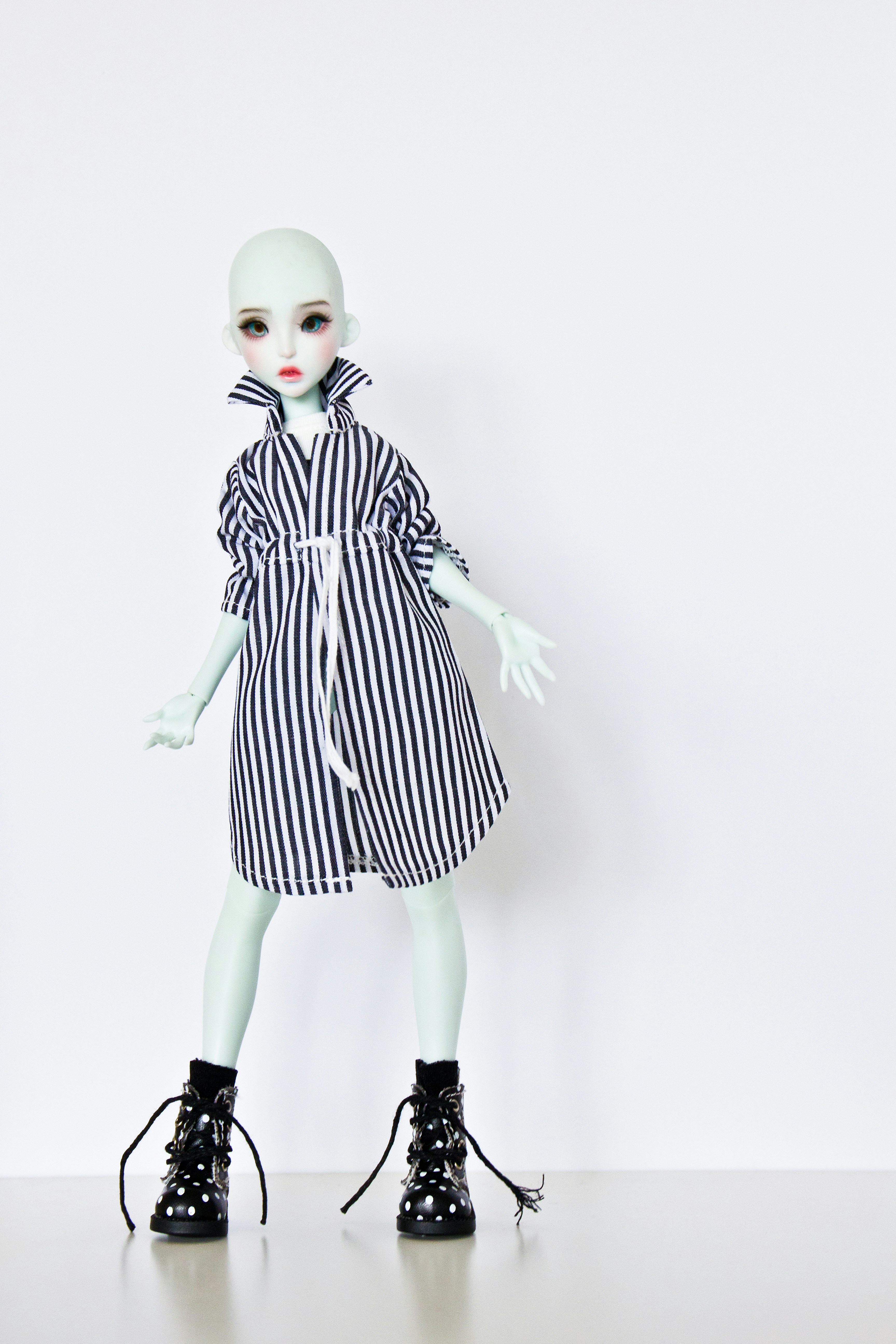 Striking Stripes: A Fashion Doll Stands in Minimalist Studio
