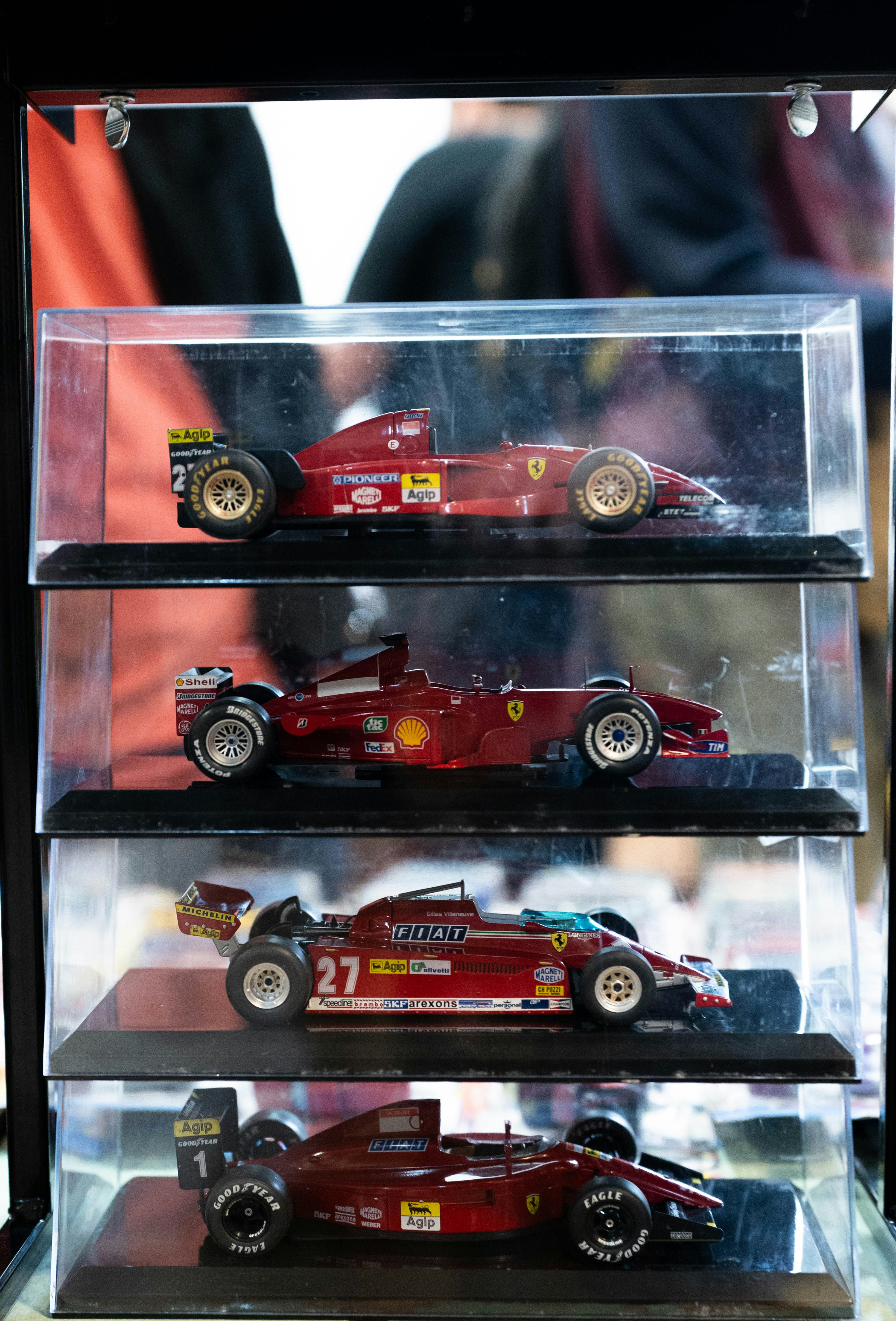 Stacked Red Formula Cars in Glass Display Case
