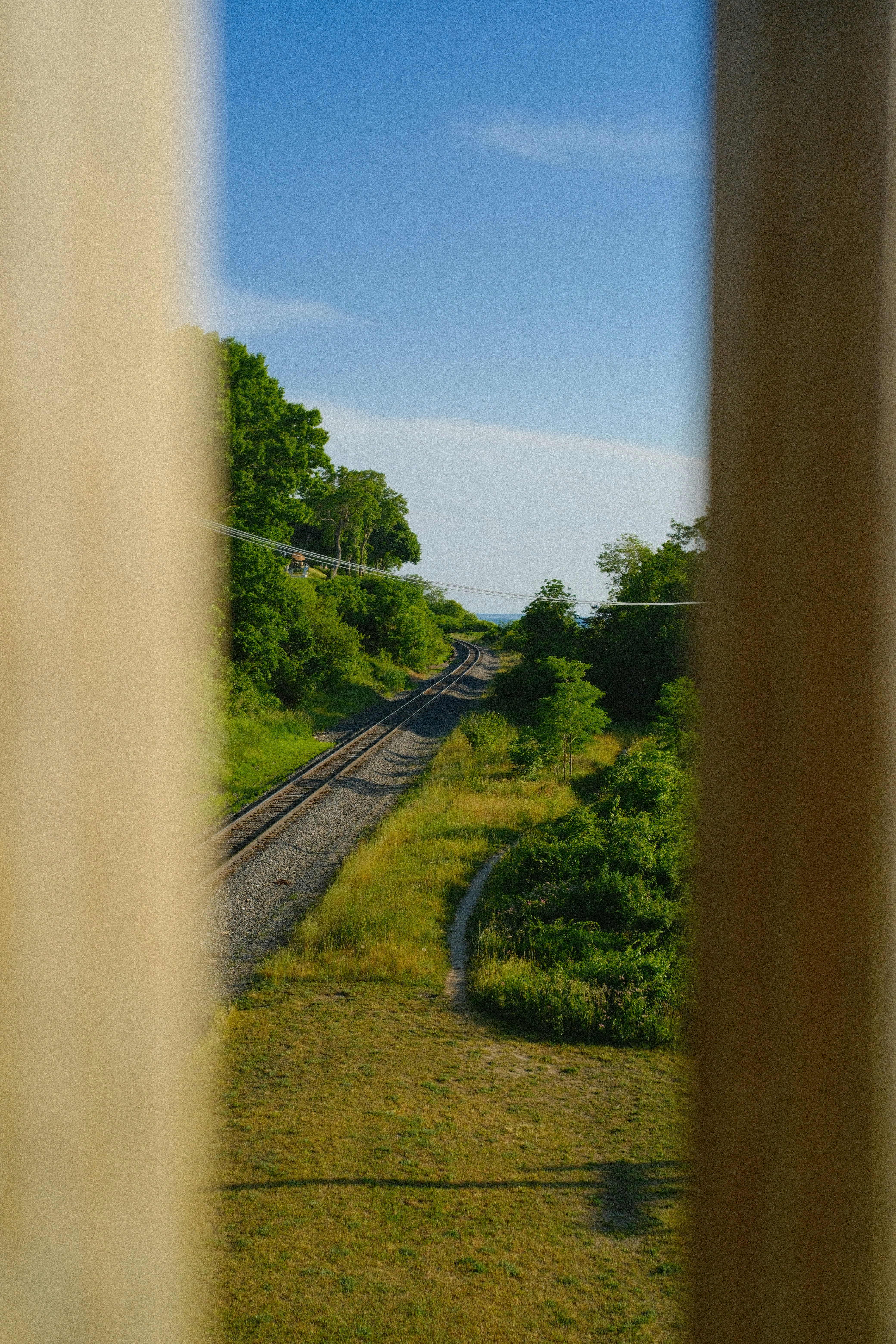 Train Tracks Through the Gap Between Wooden Slats