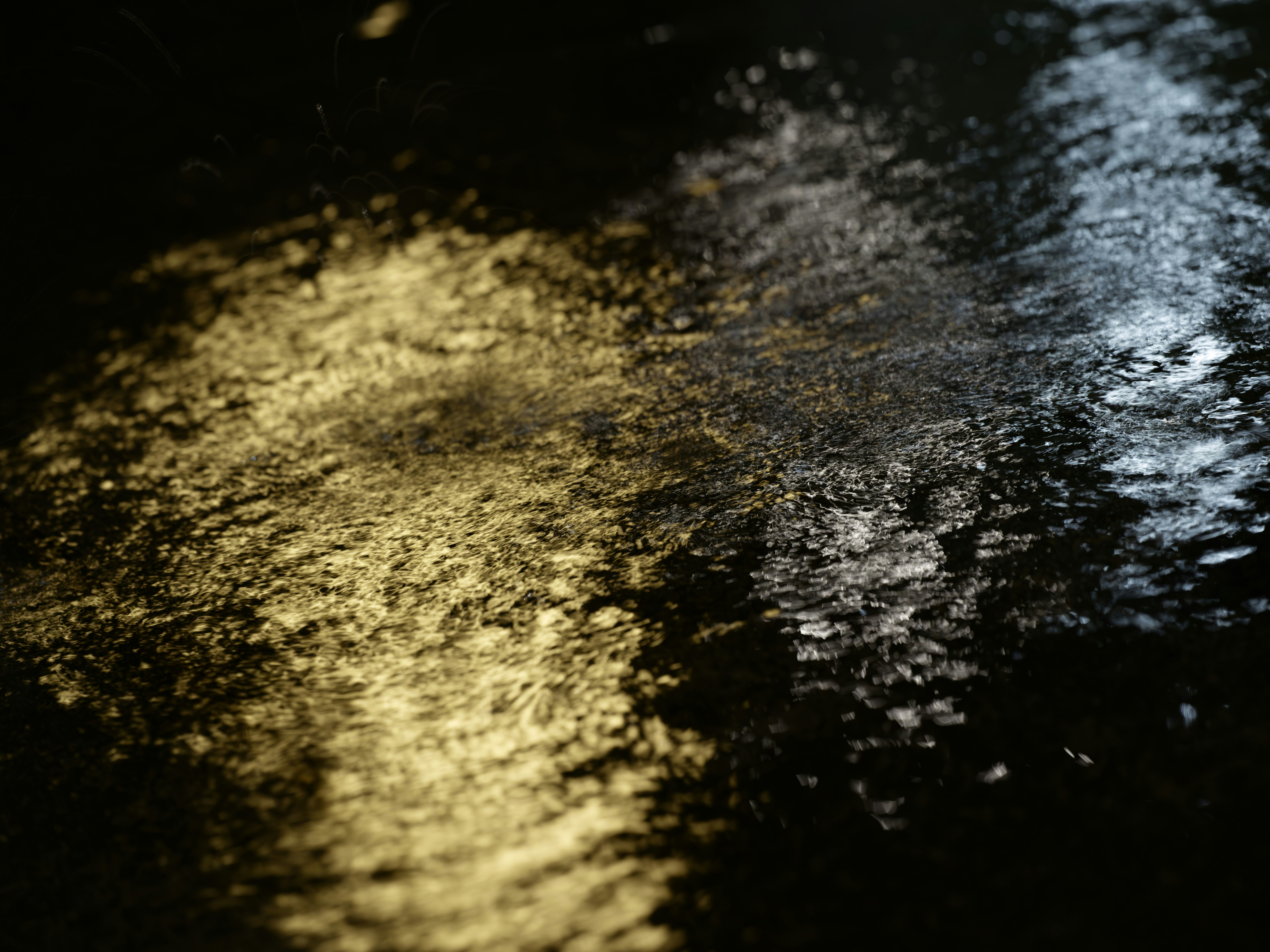 Golden and silver shimmering powder on a dark surface.