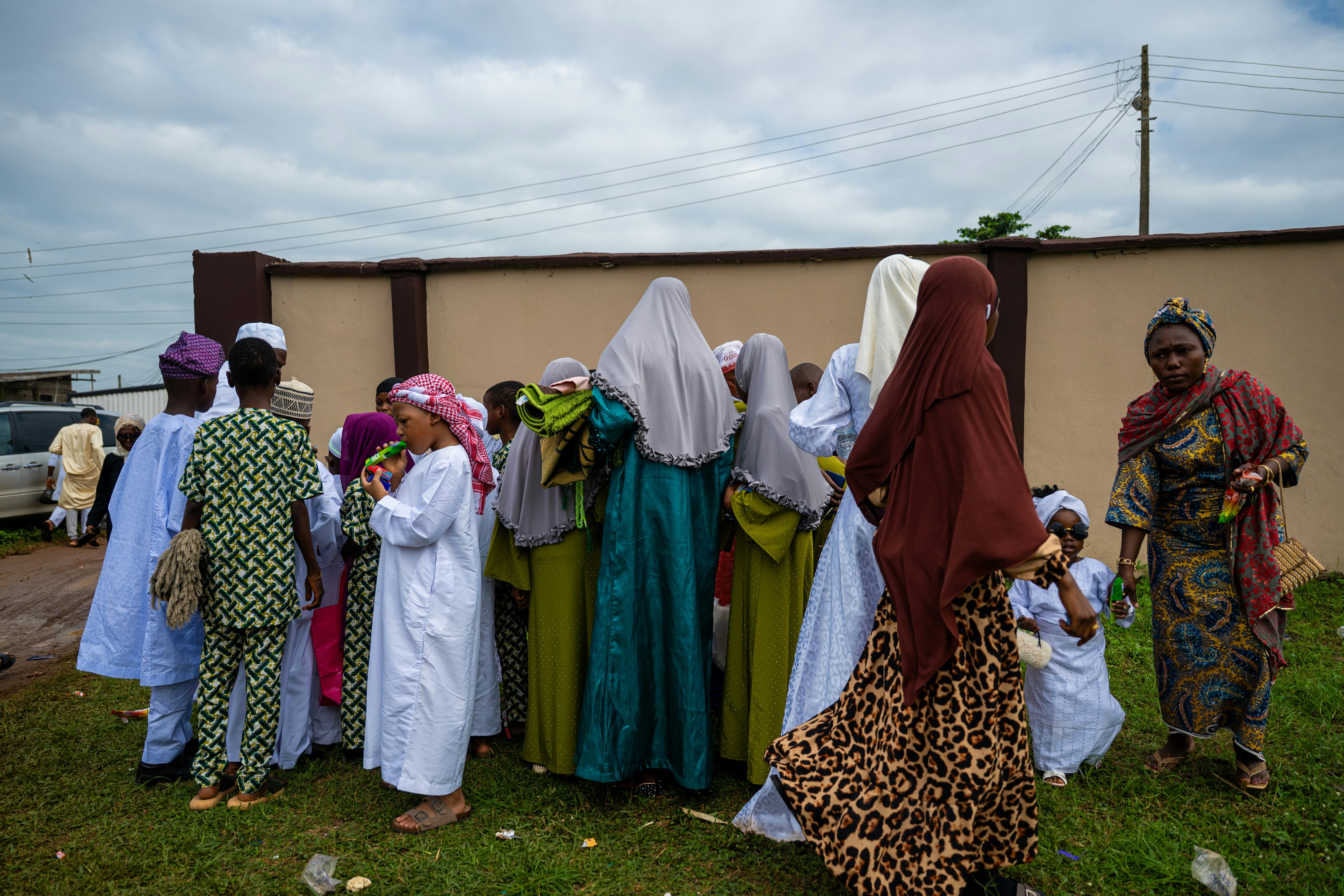 Women and children in traditional dress gather outdoors.