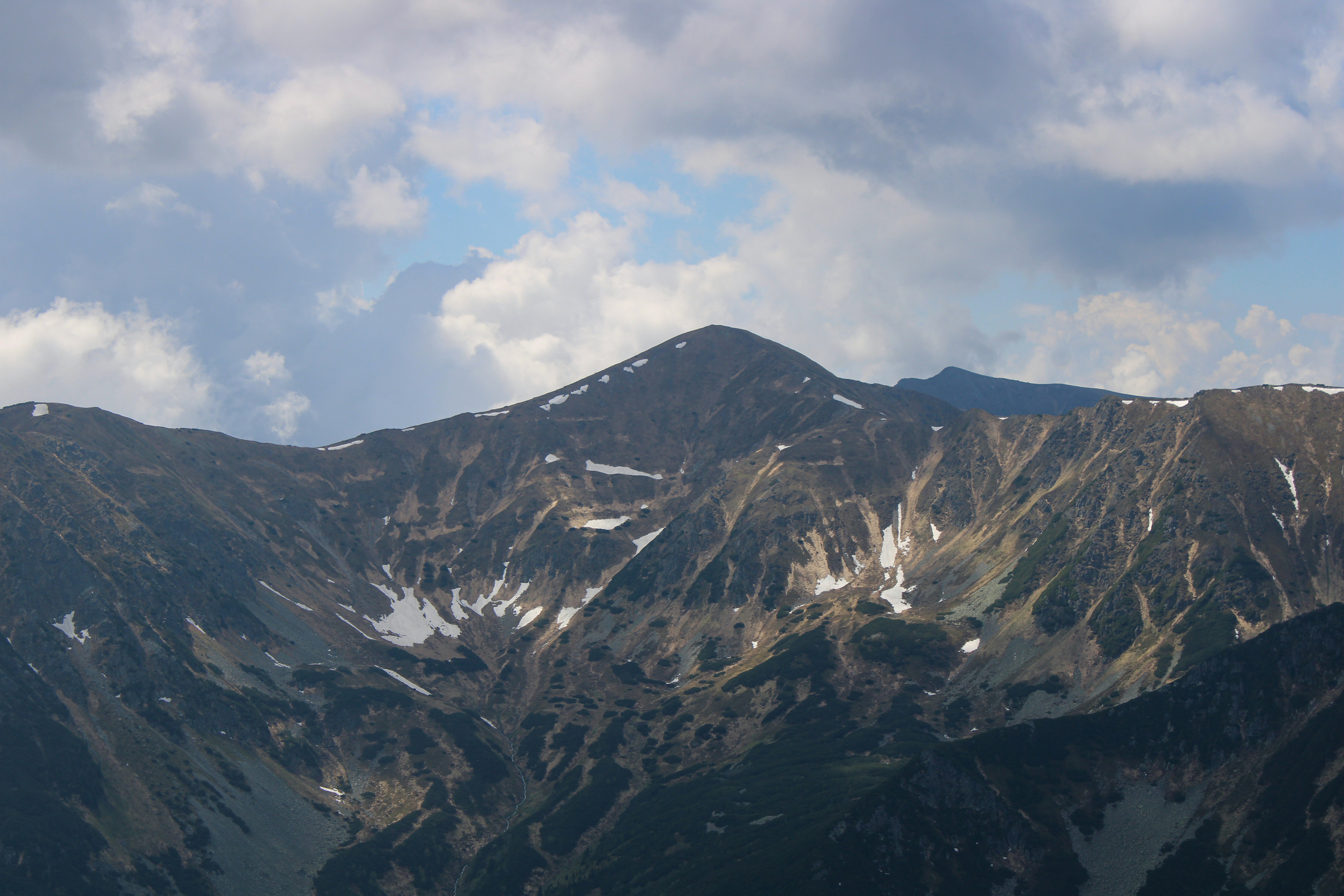 Alpine Crown: Snow-dusted Crests Beneath a Brooding Sky