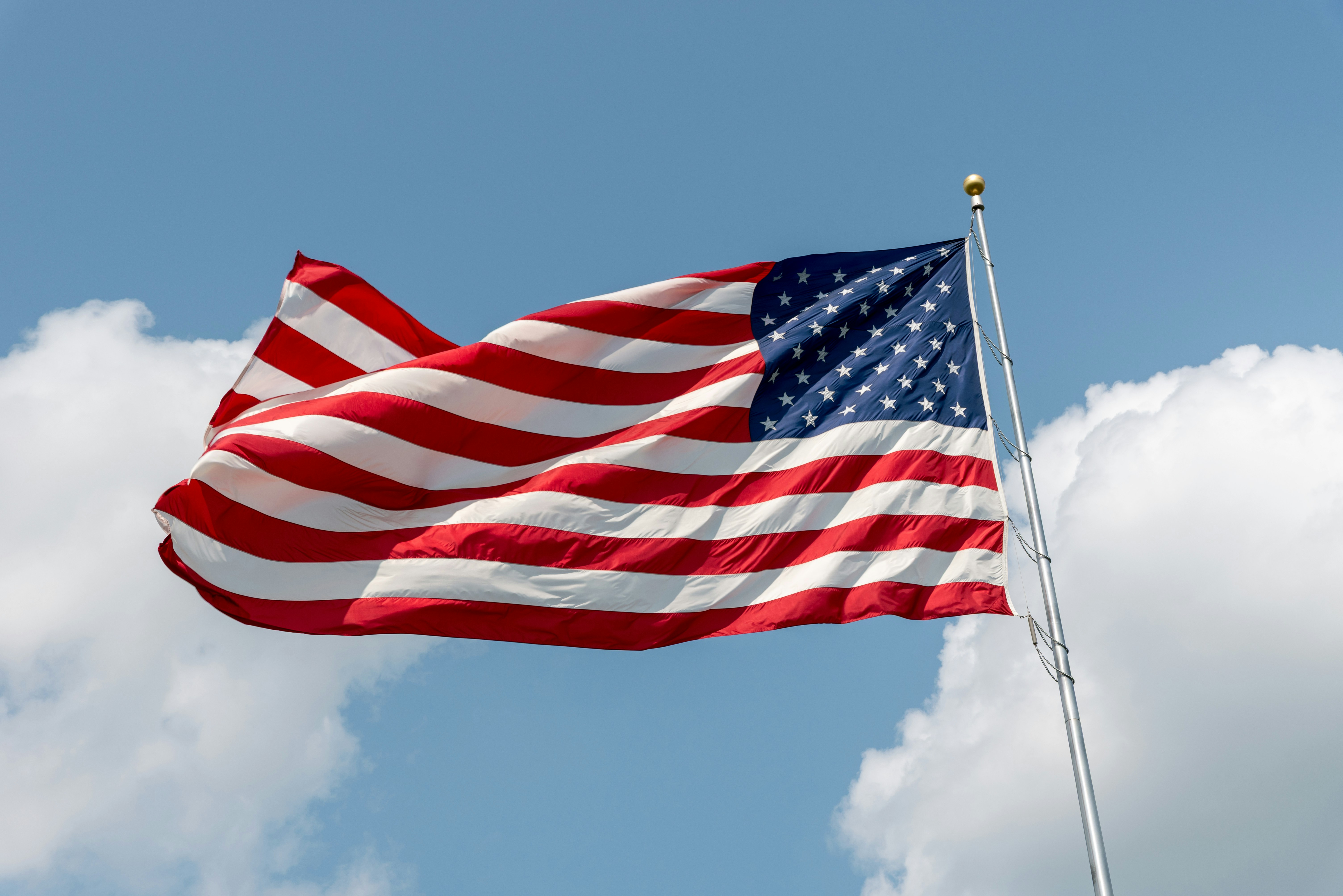 Windward Emblem: An American Flag Soaring Against a Clear Sky