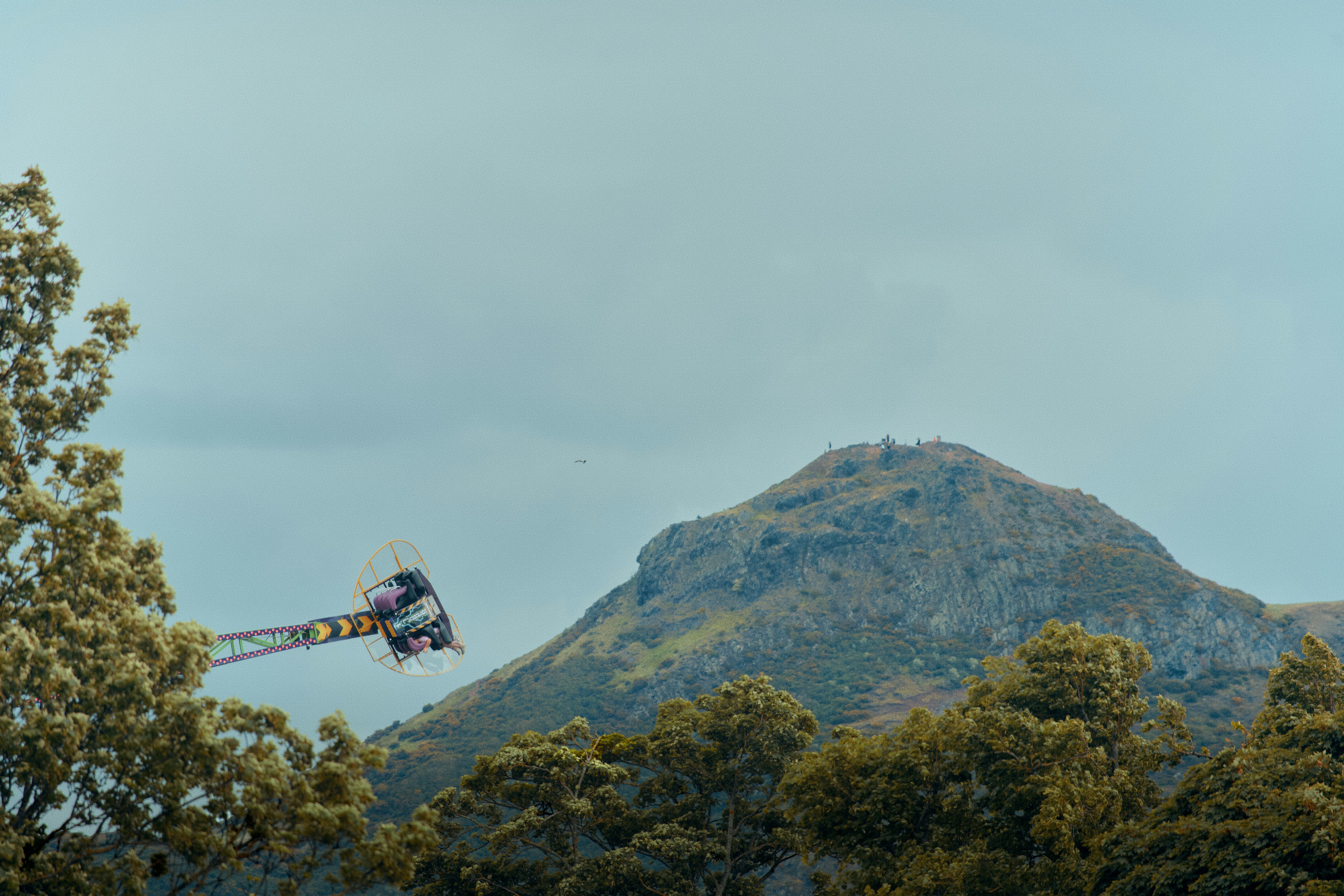 Lone Aerial Crane Against a Quiet Hillscape