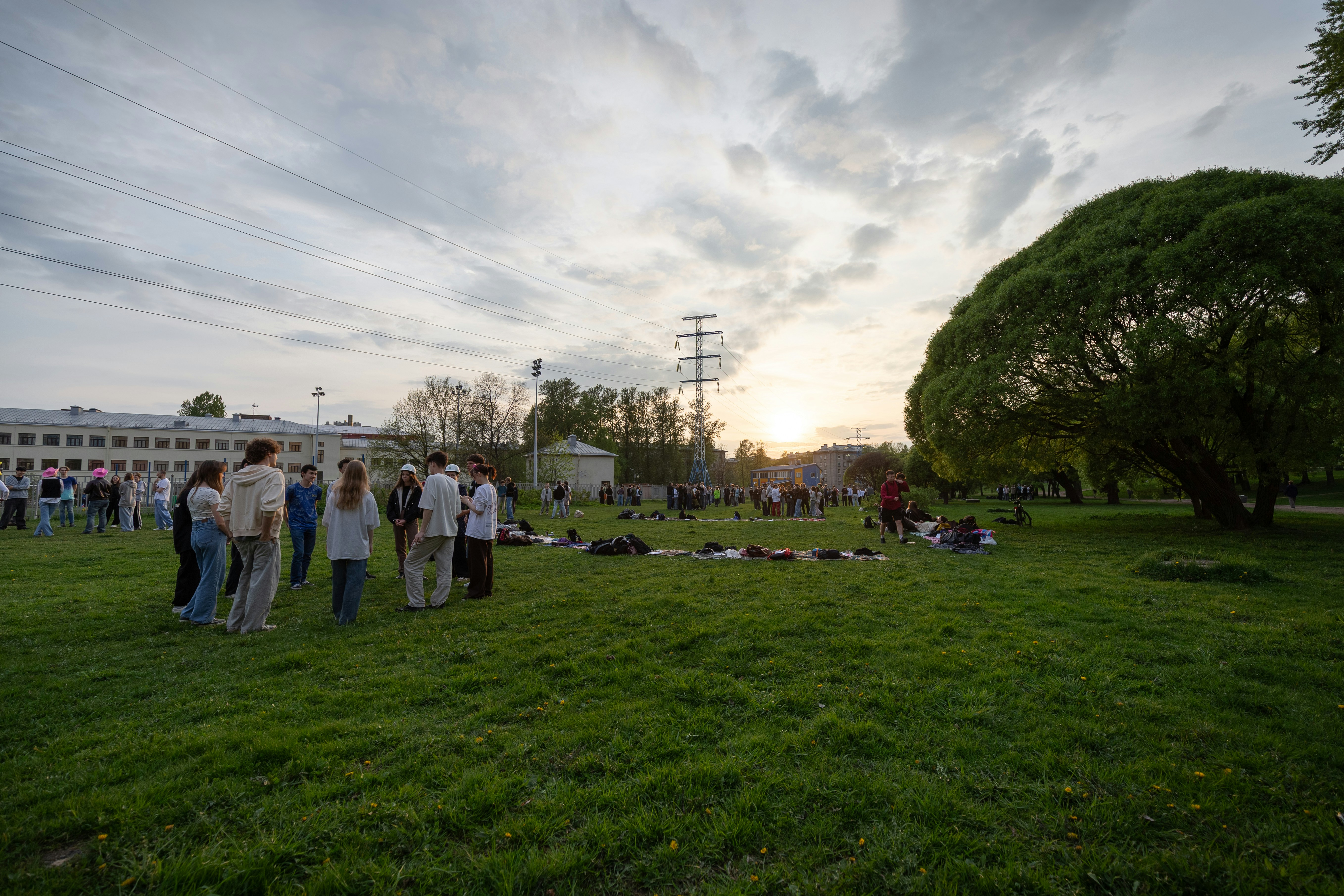 Evening gathering on the grassy field under a cloud-filled sky