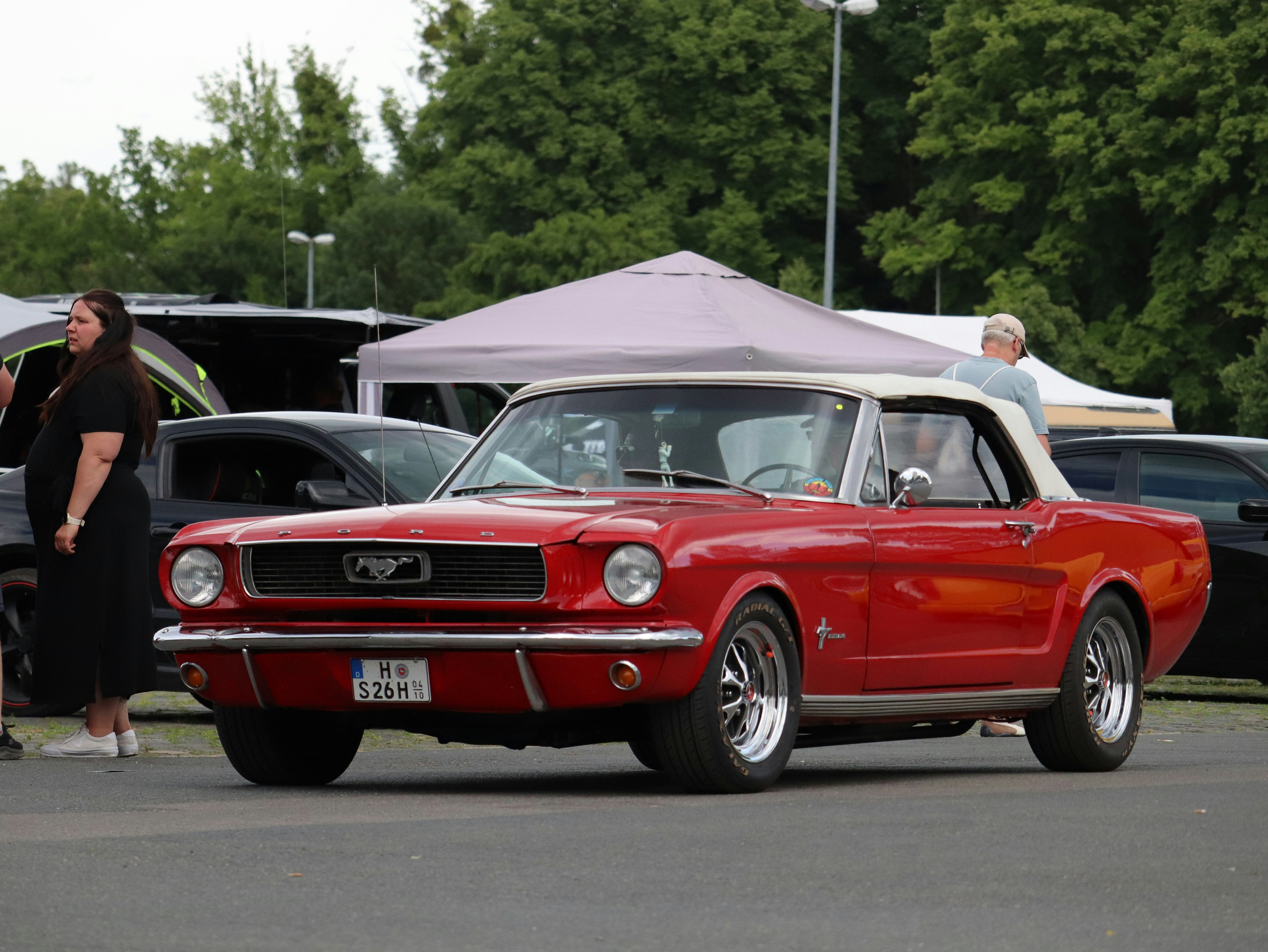 Red Classic: A gleaming Ford Mustang at a daytime car show