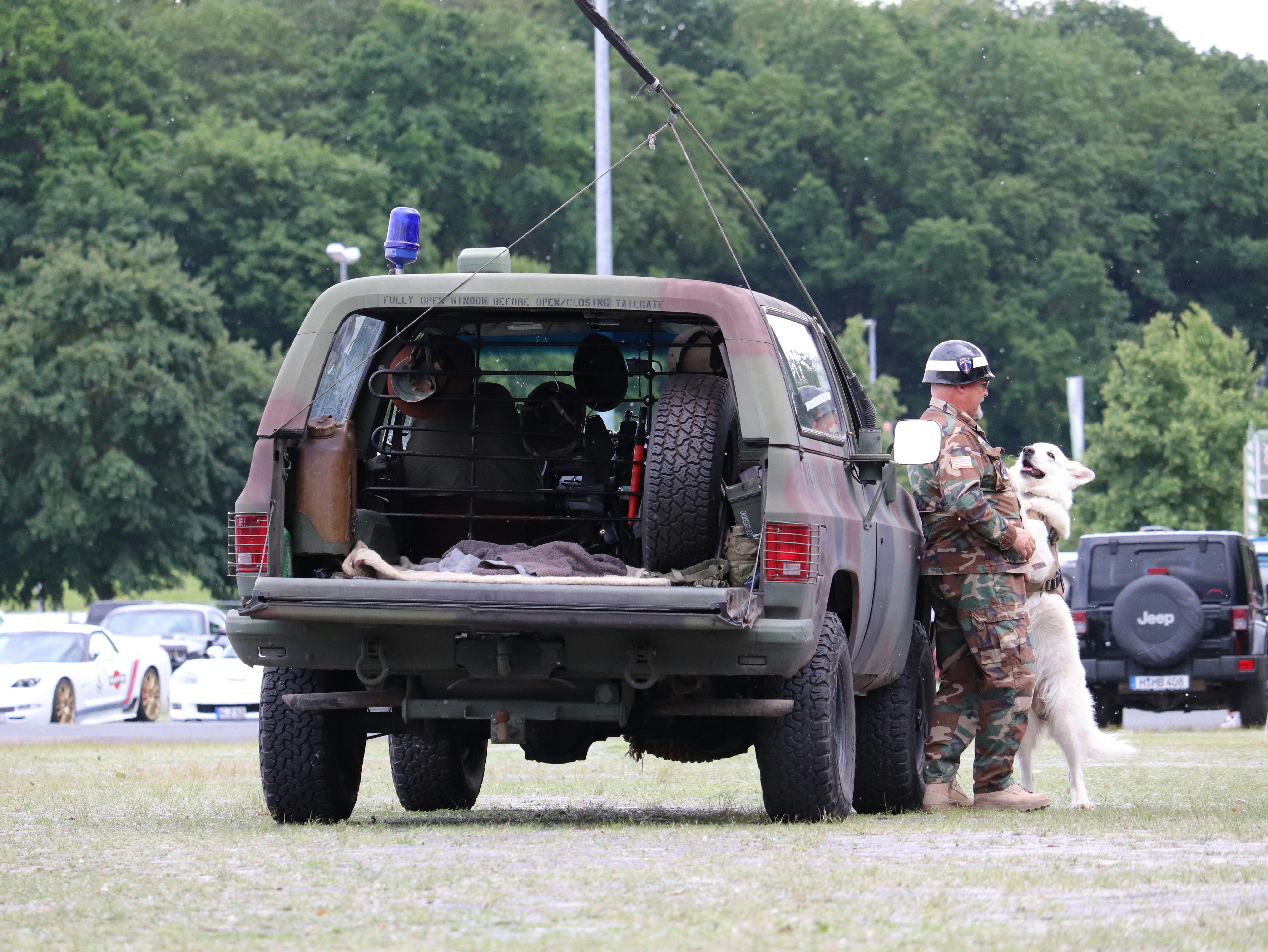 Dog with a Soldier: A Close Moment by the Vehicle