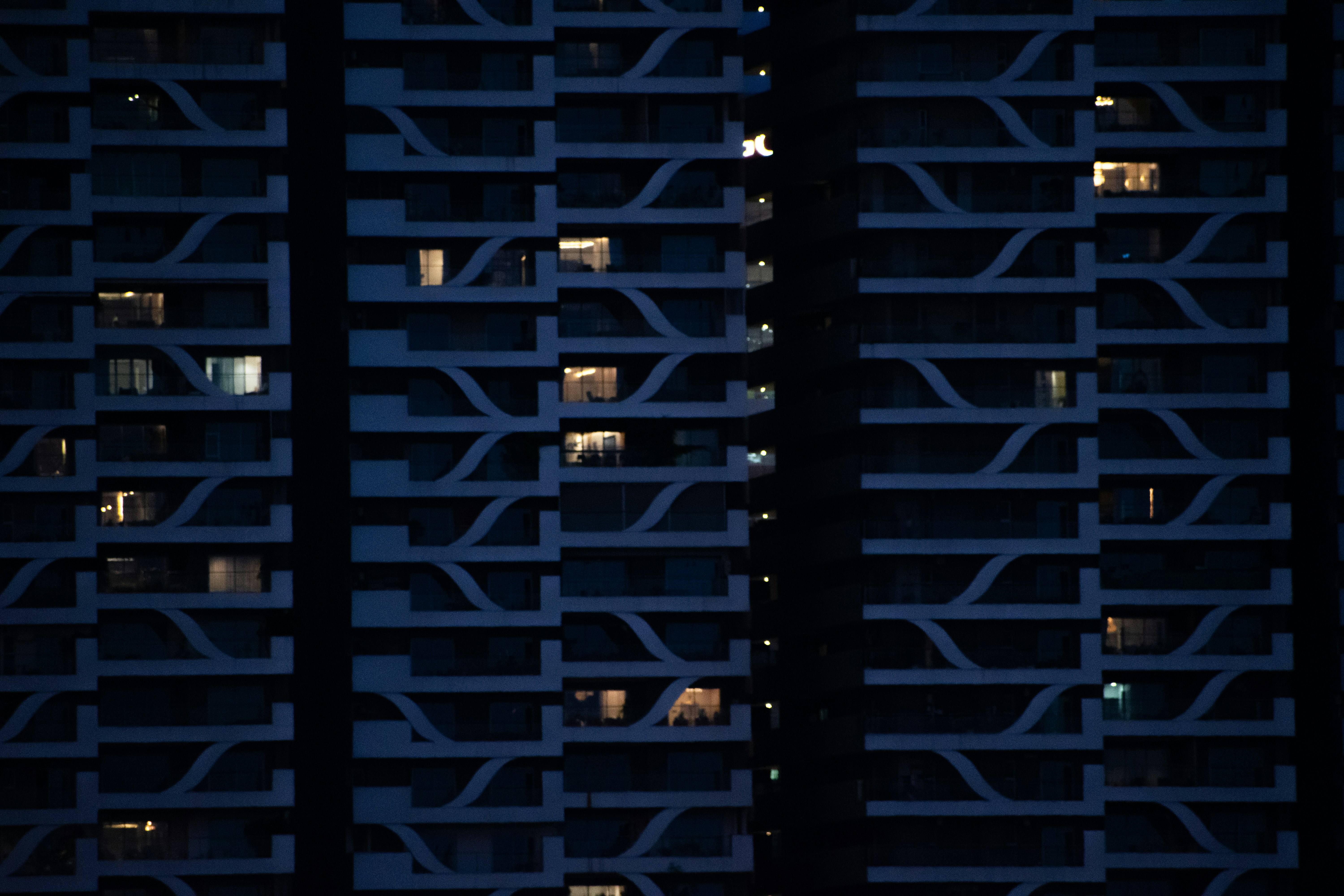 Night Facade: Geometric Lattice Windows in Blue Rigorous Pattern