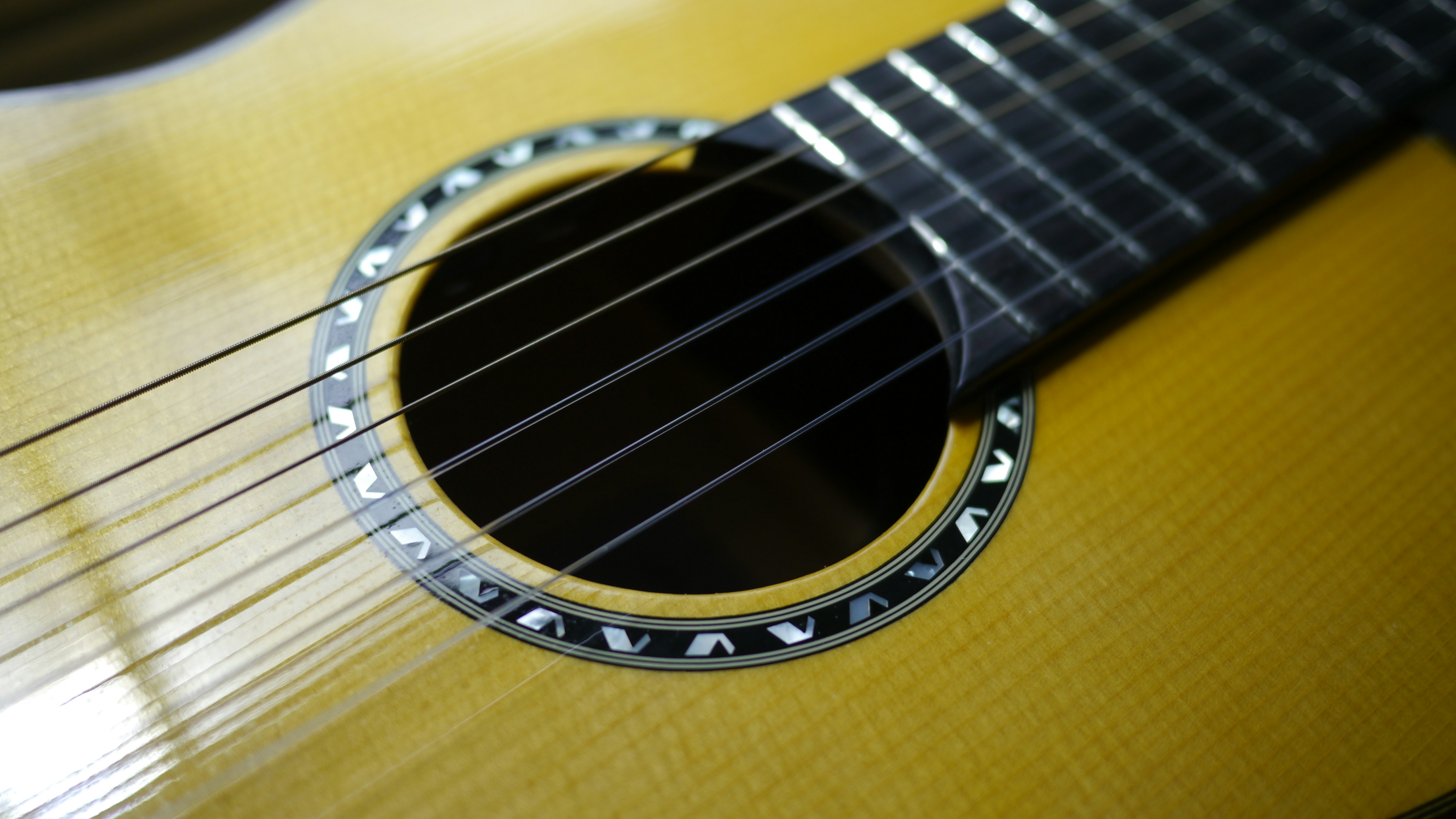 Sunburst Resonance: Close-up of an Acoustic Guitar Sparkling Under Light