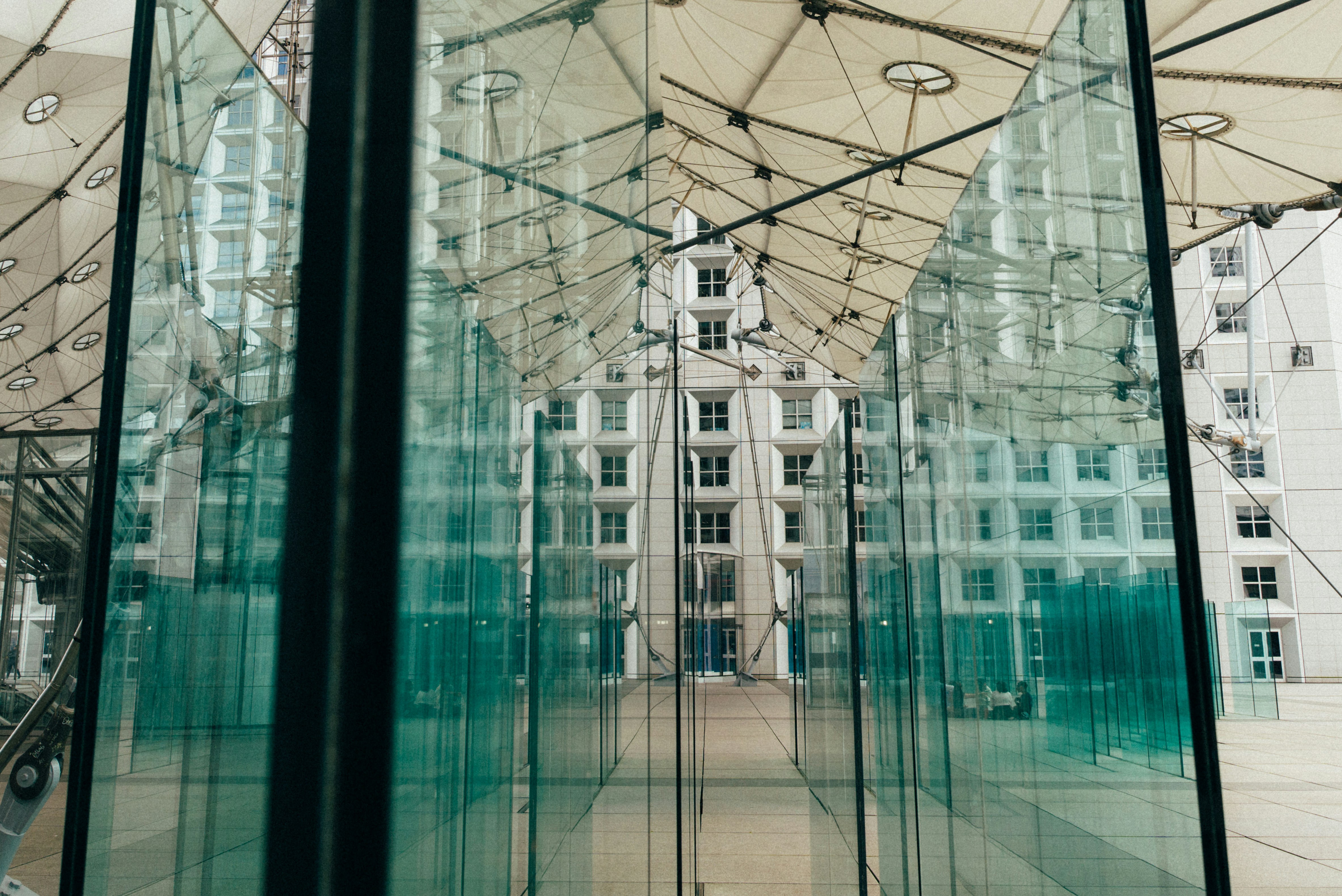 Modern glass architecture reflecting a white building.