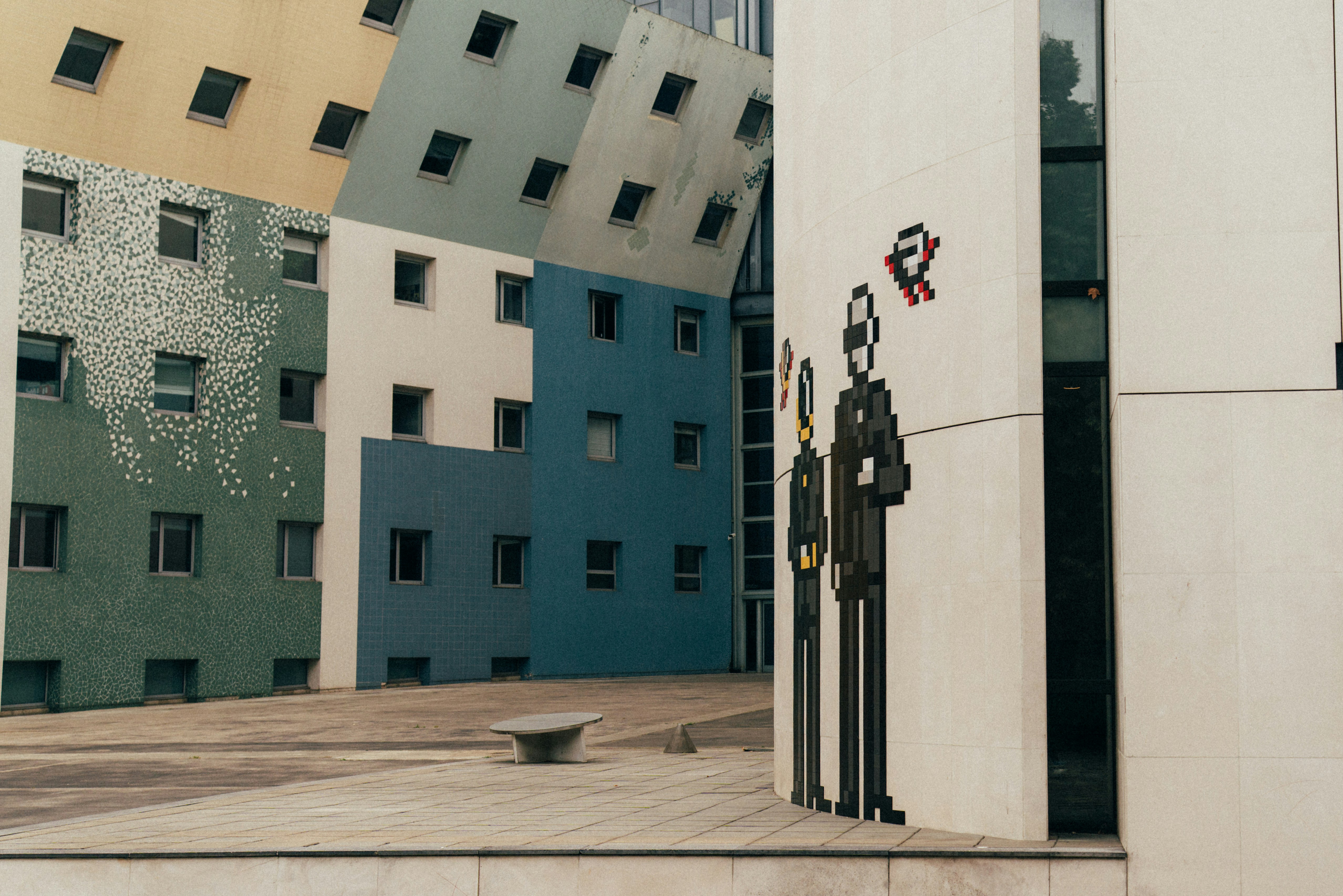 Abstract building facade with a mural of two figures.