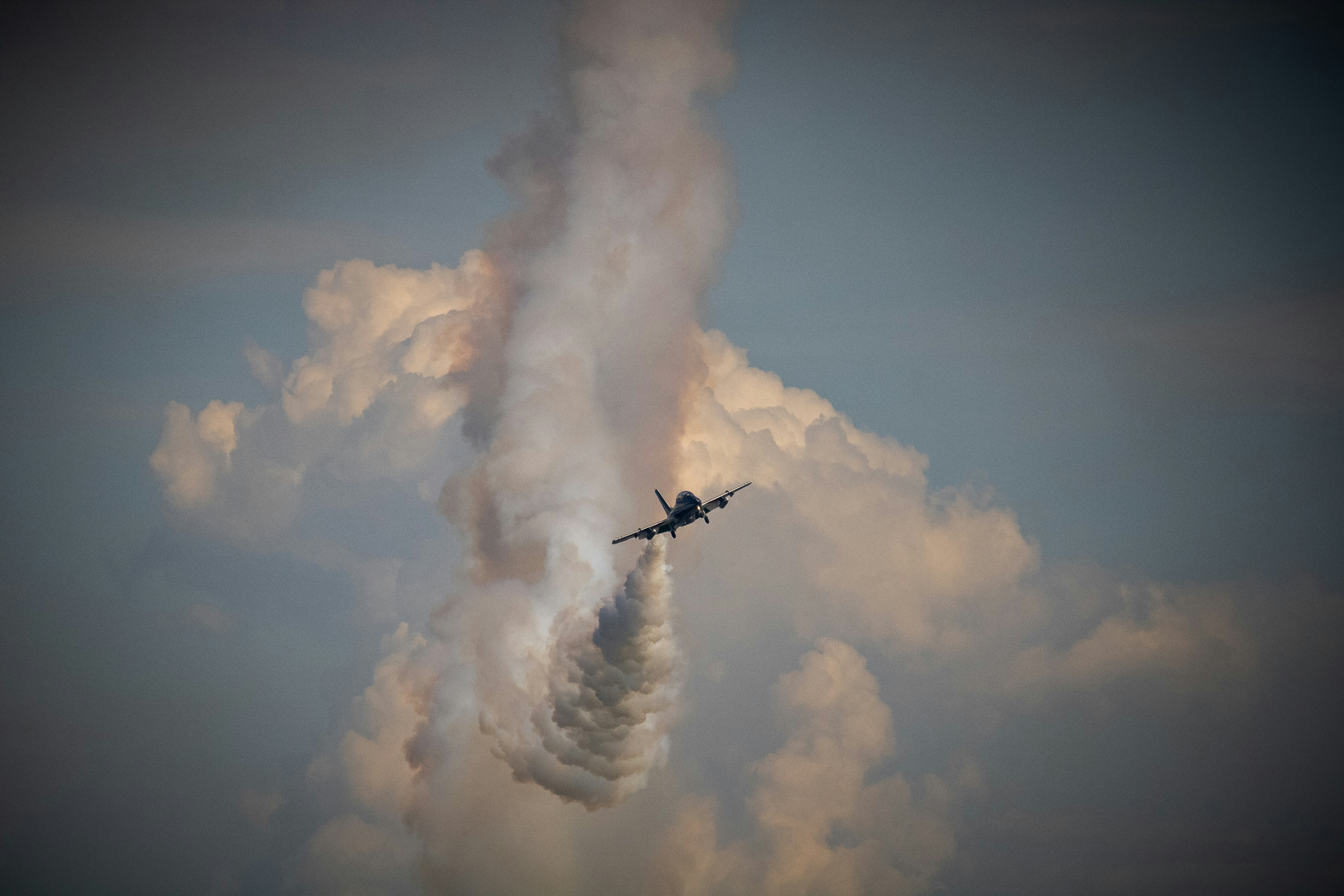 Smoke and Sky: A Solo Jet Carves Through a Column of Cloud