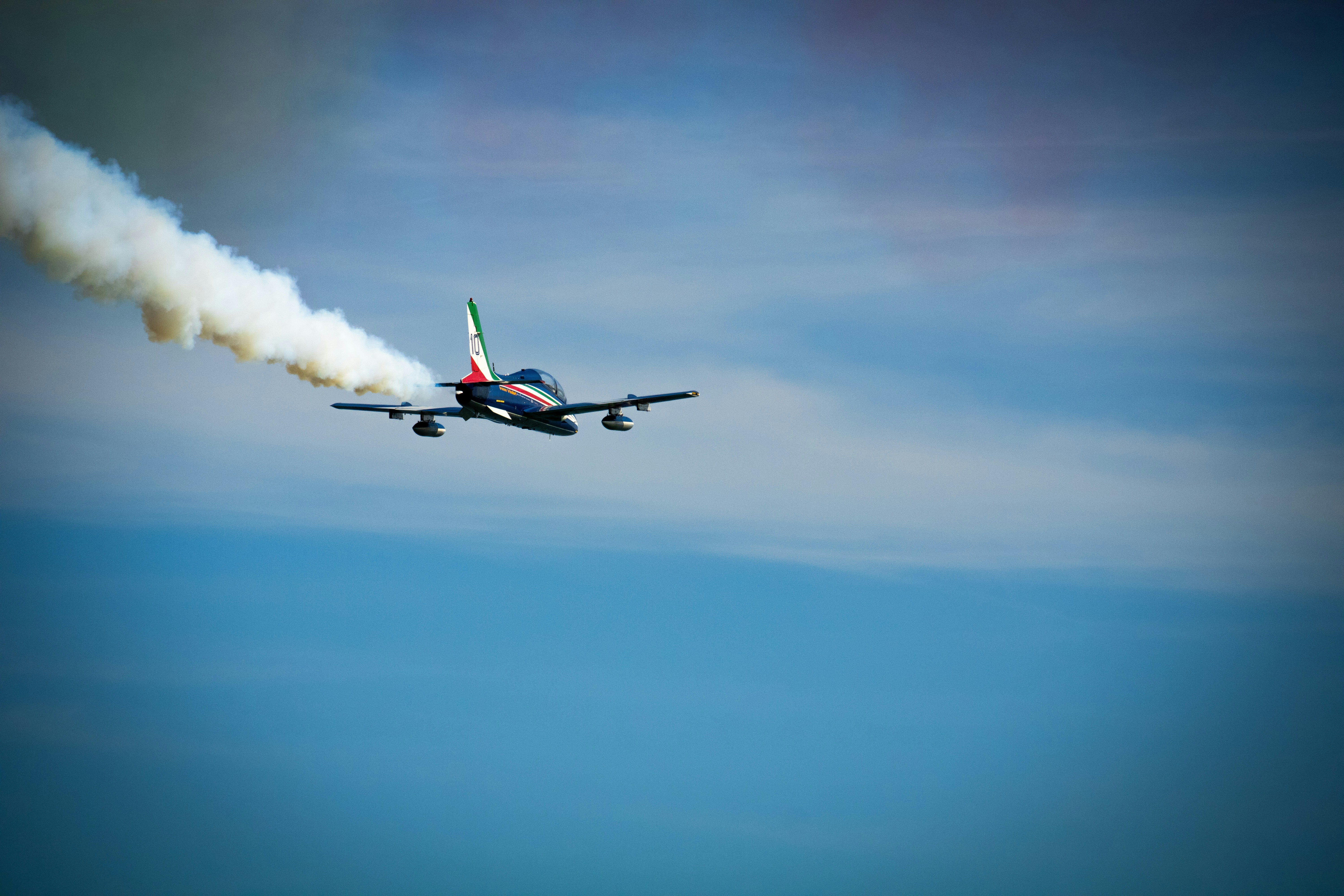 Smoke Trails and Silence: A solo aerobatic run against a bright blue canvas