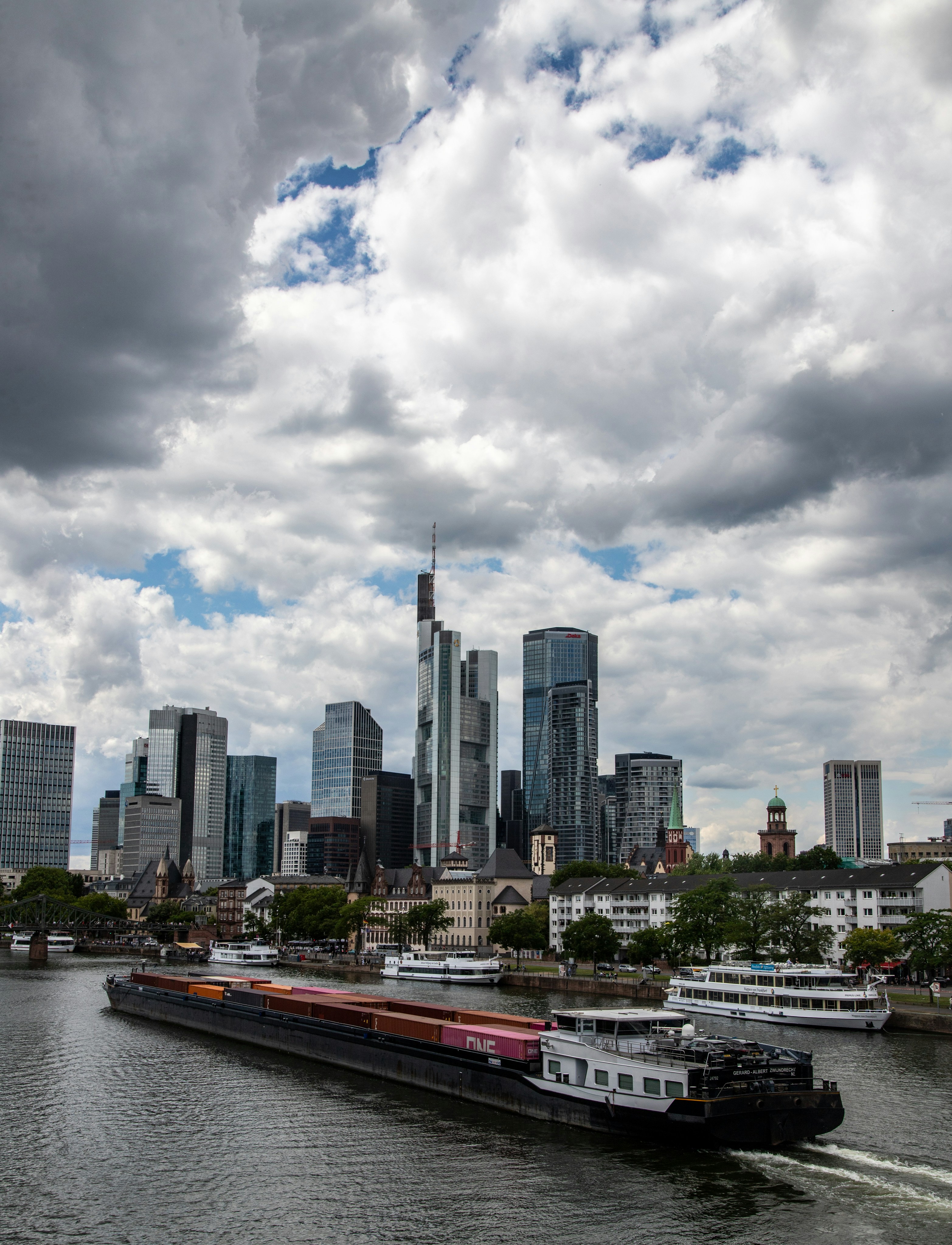City Pulse on the River: Skyscrapers Silhouetted by Cloudscape