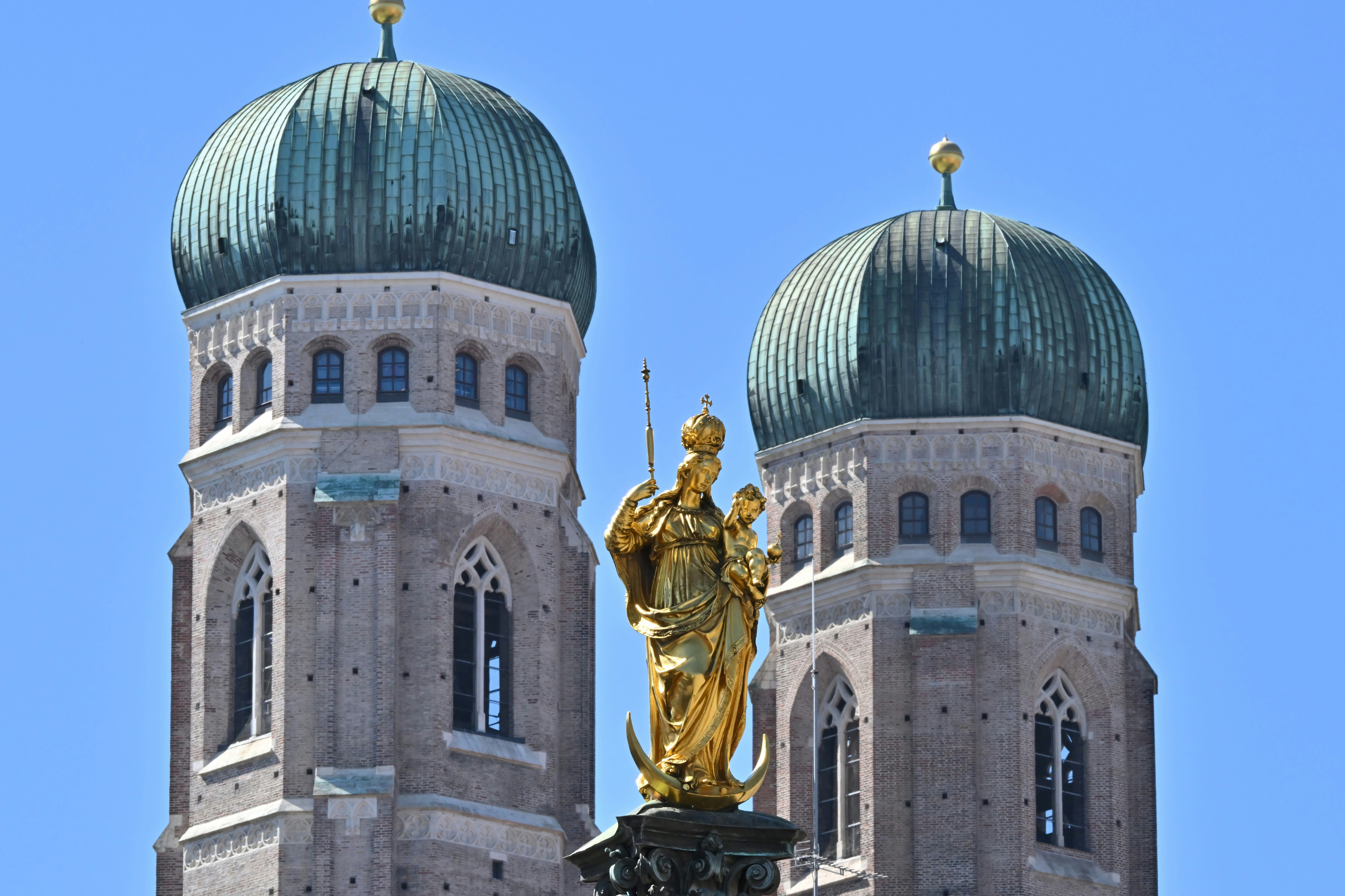 Golden Statue Between Twin Domes: A Skyward Glimpse at Munich Cathedral