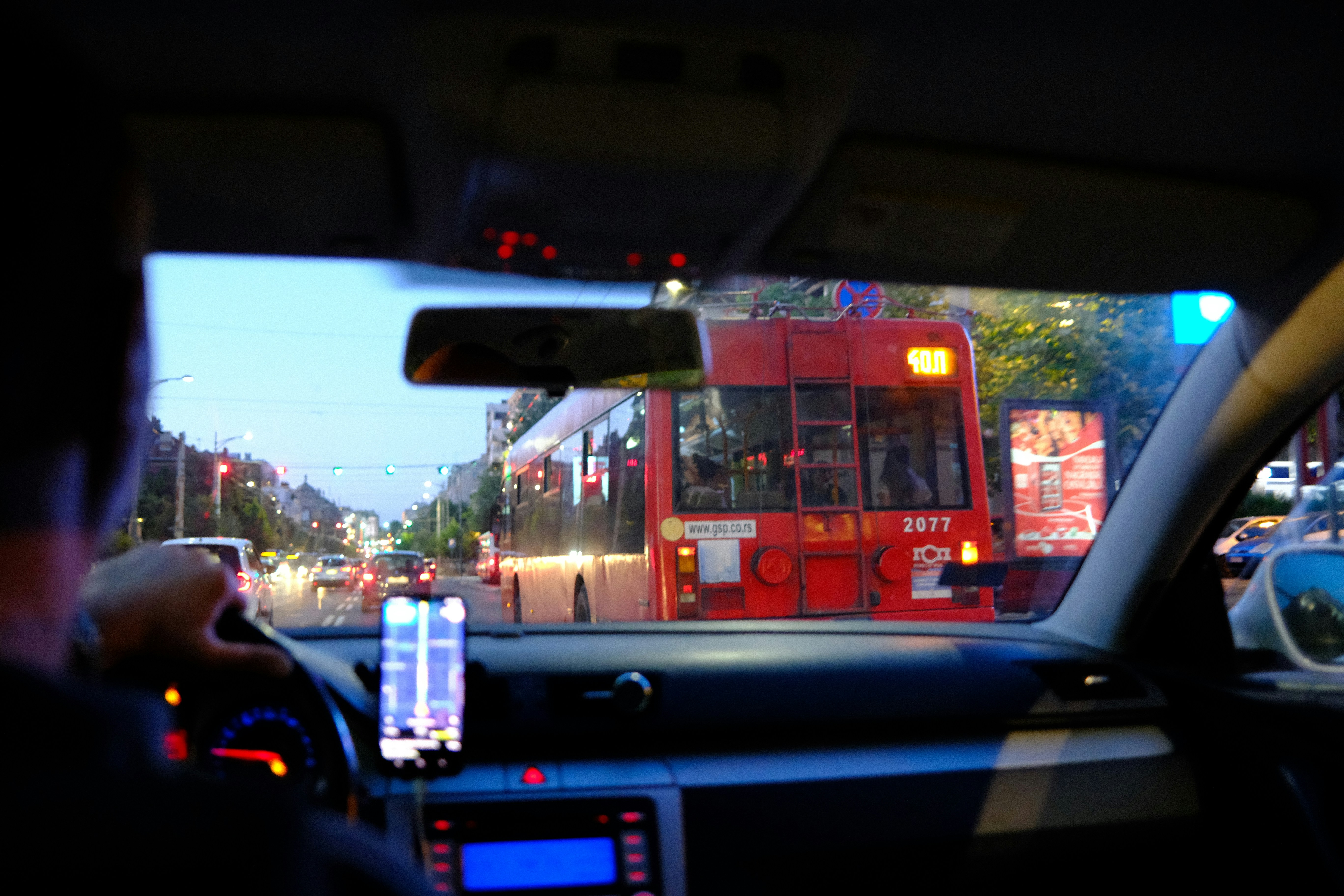 Red Streetcar in View Through the Car Windshield at Dusk
