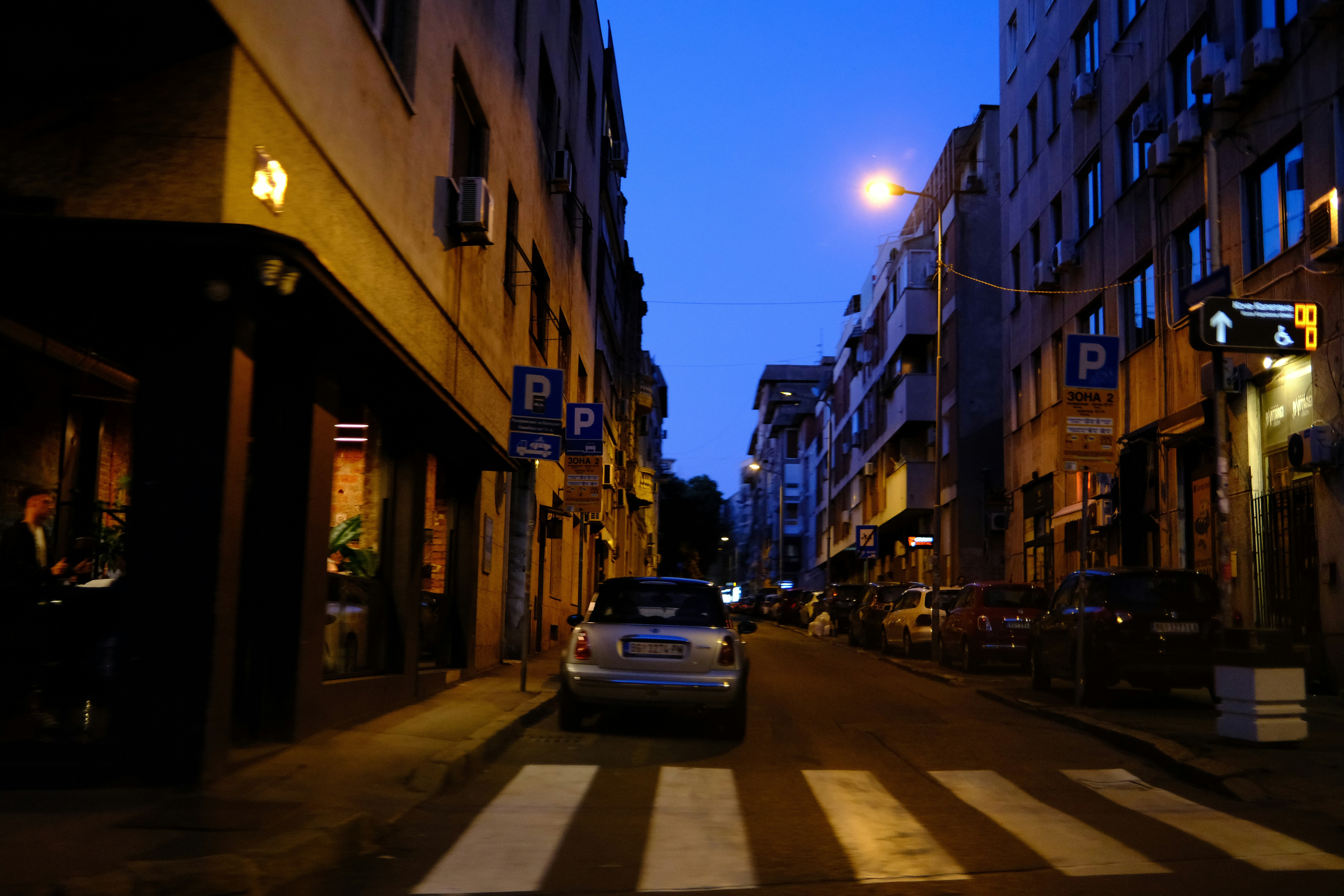 Urban Night Corridor: Headlights Guiding Through a Quiet Street