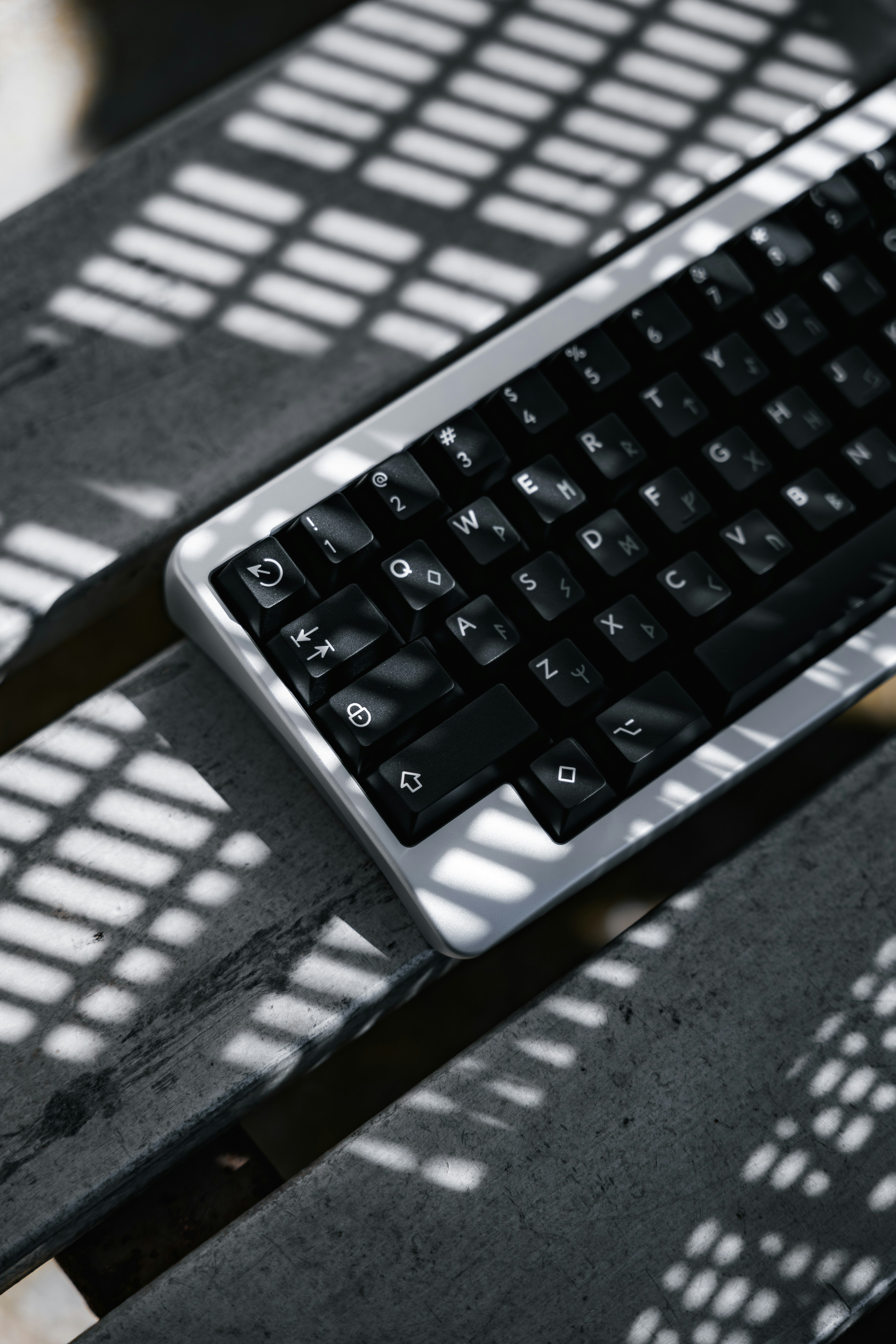 Shadowed Keys: a concrete keyboard basked in patterned light