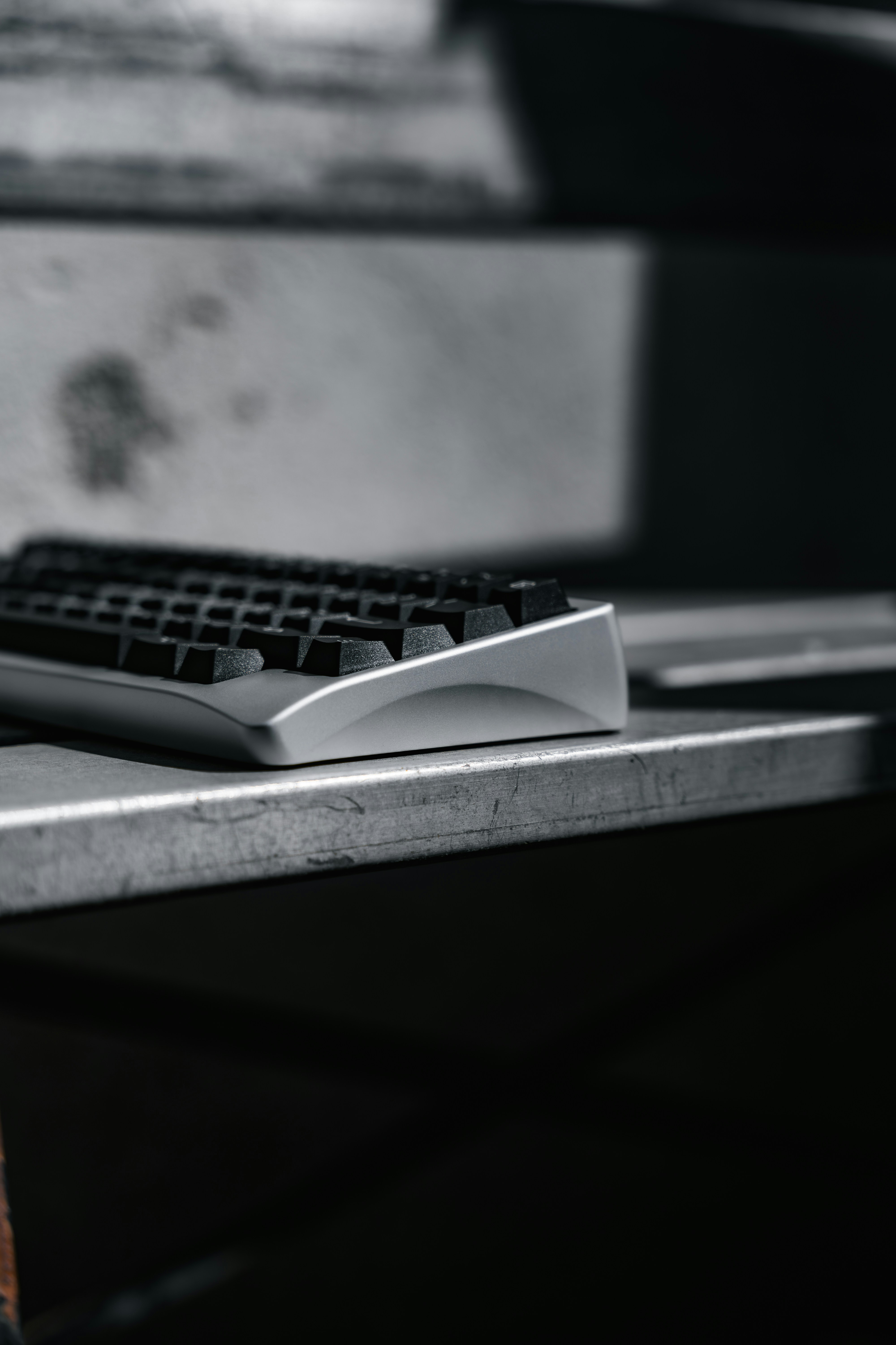 Muted Keys, Quiet Shadows: A Close-Up of a Desktop Keyboard on a Worn Surface
