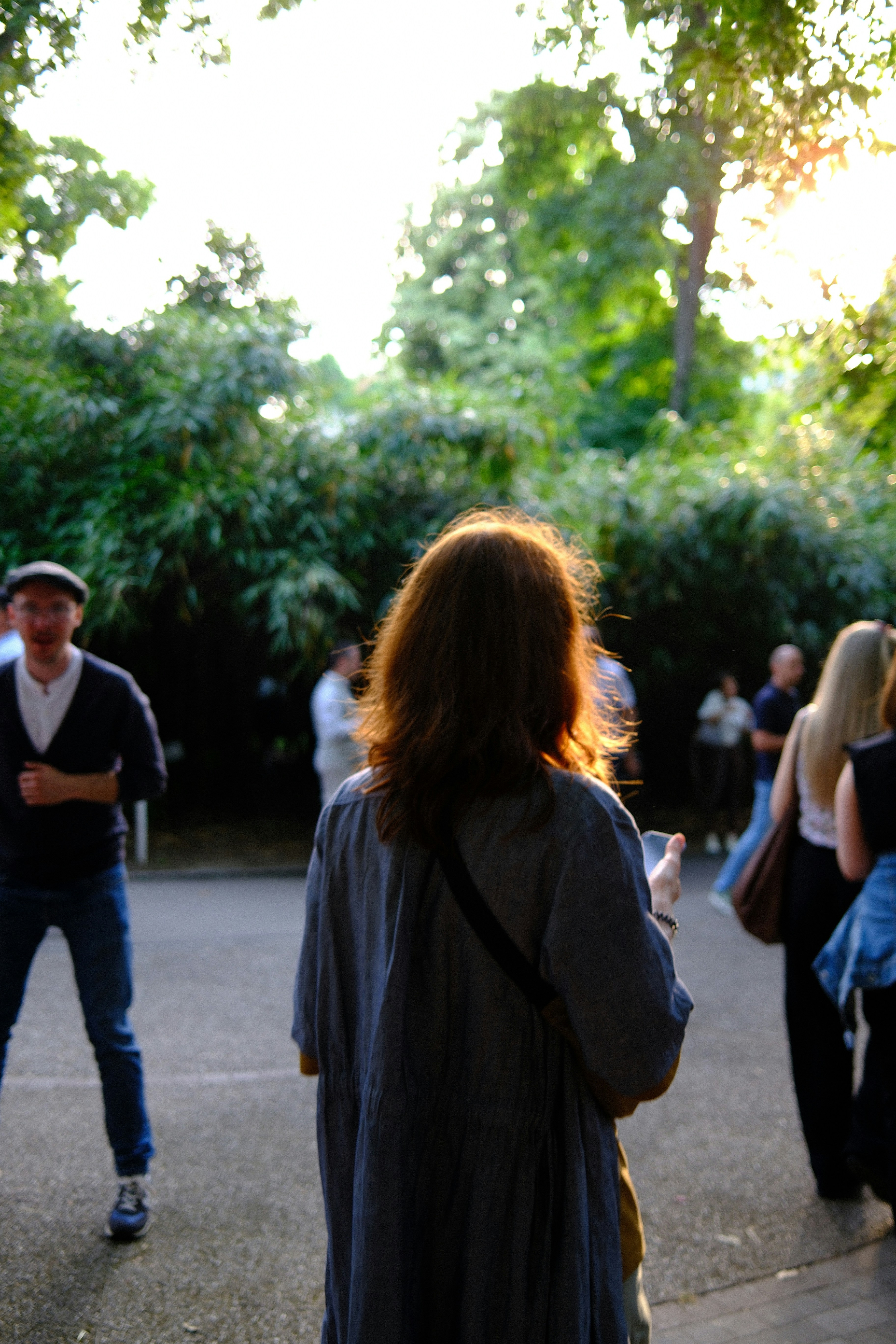 Behind the Crowd: A Moment of Conversation in the Park