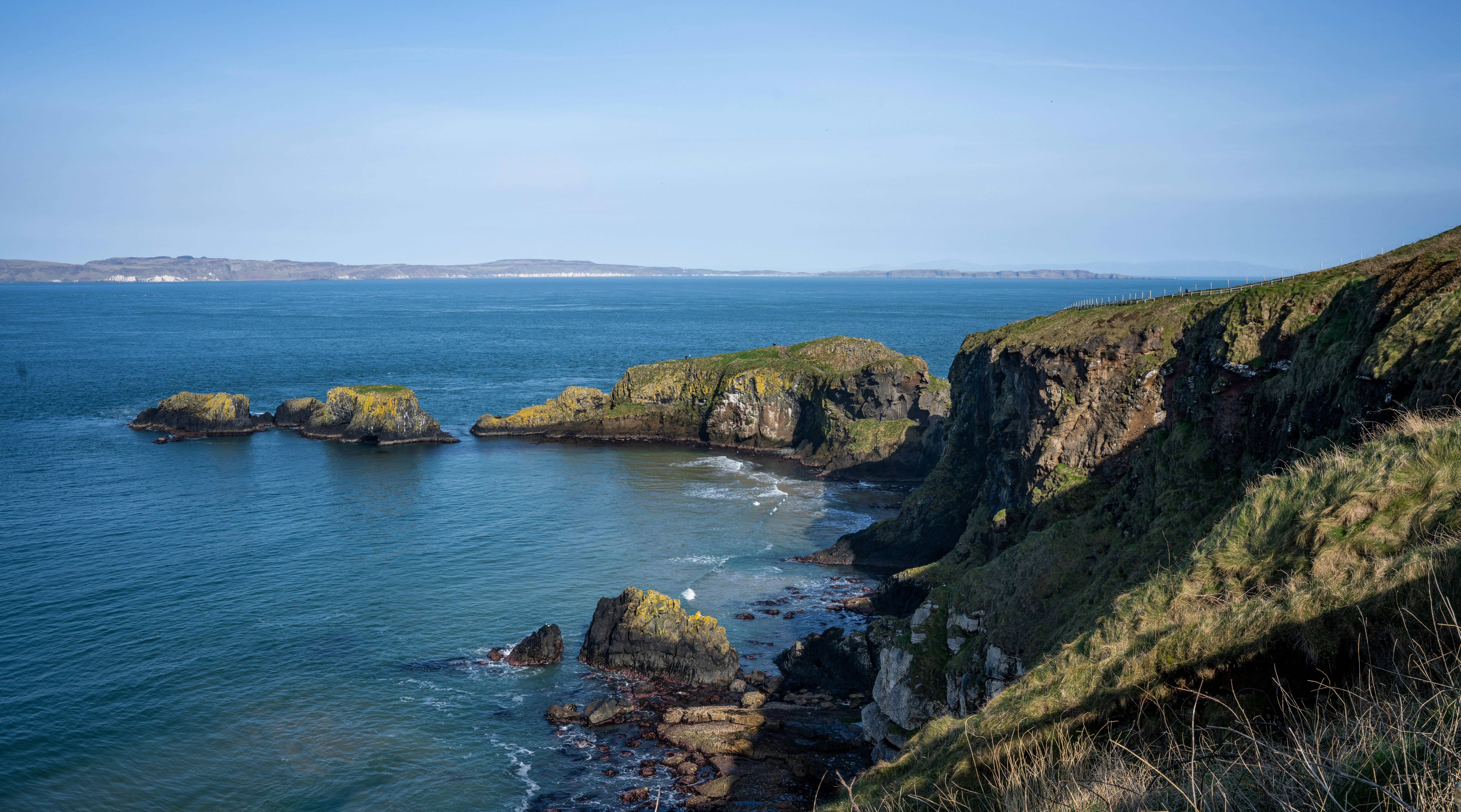 Cliffside Atlantic Vista: Sunlit Rocks and Azure Sea