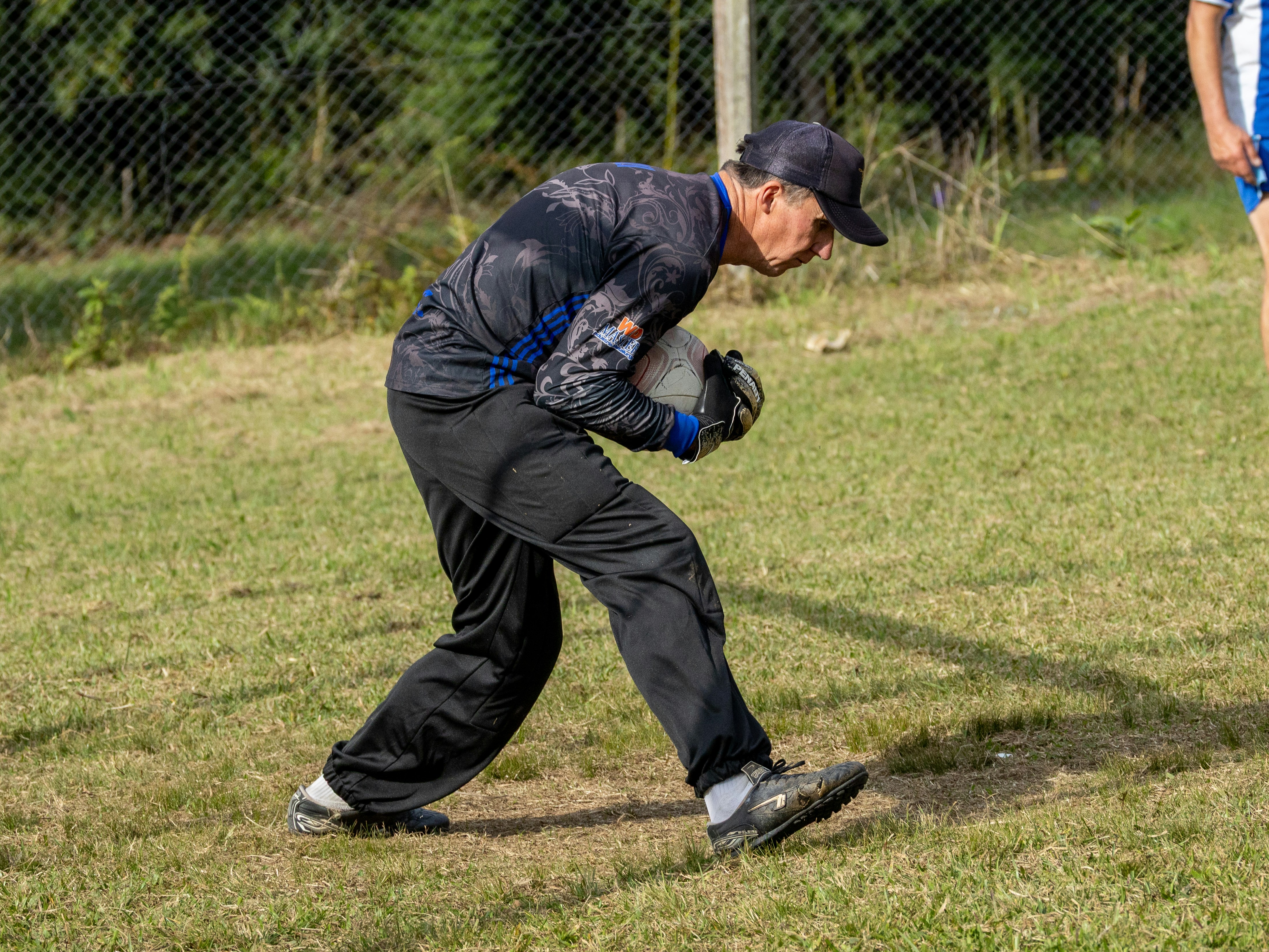 Man in sportswear catching a ball during a game.