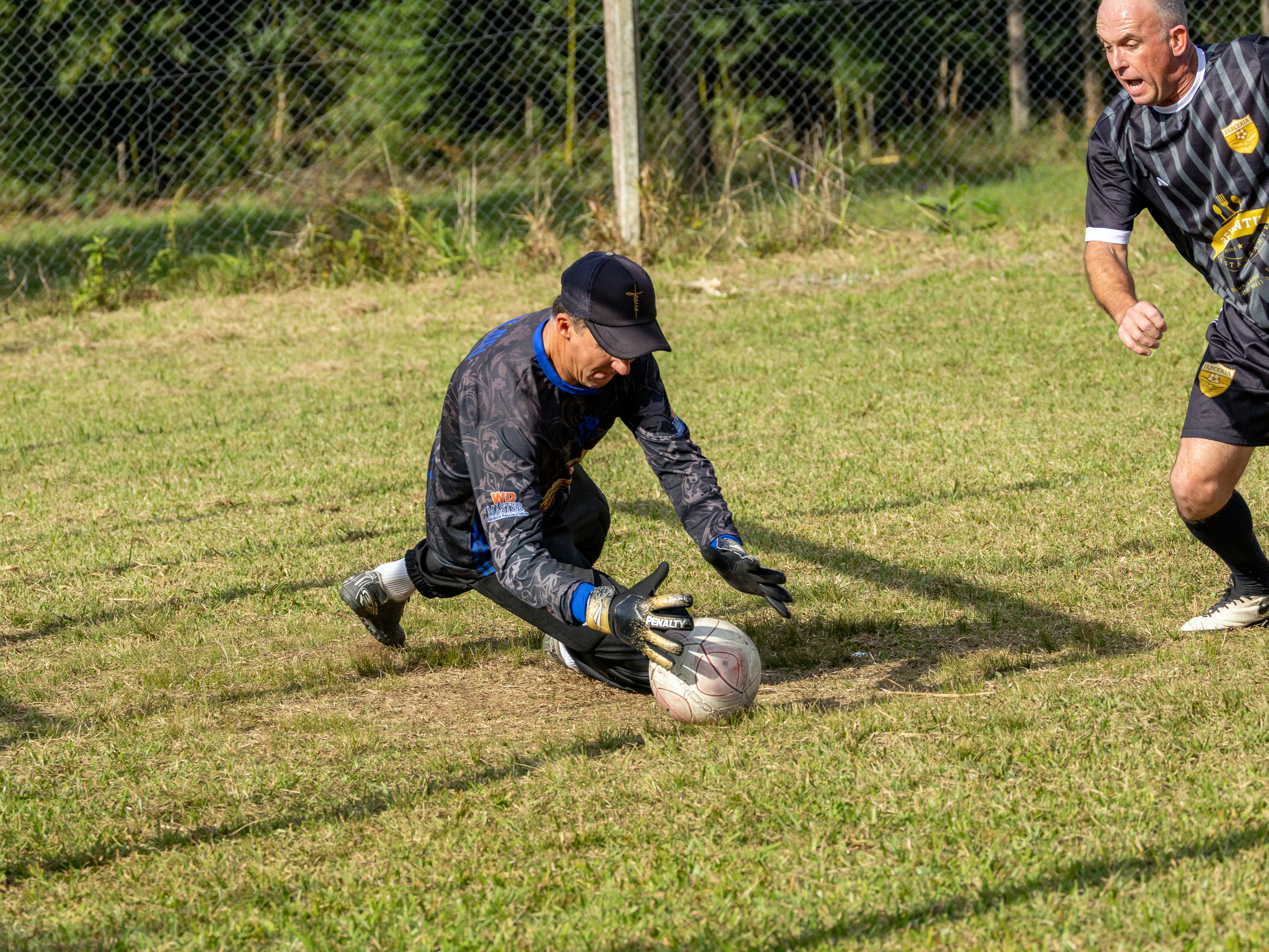 Grass-Streaked Save: The Keeper’s Low Dive for the Ball